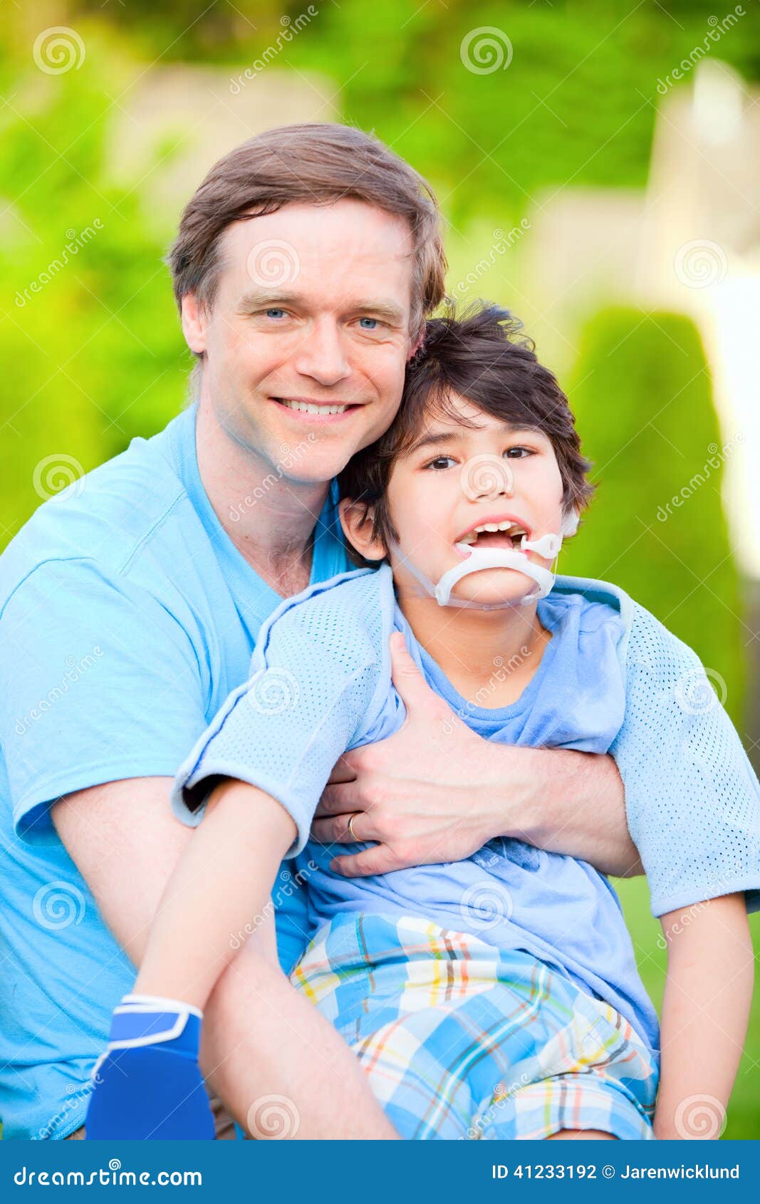 Handsome Father Holding Smiling Disabled Son Outdoors Stock Photo ...