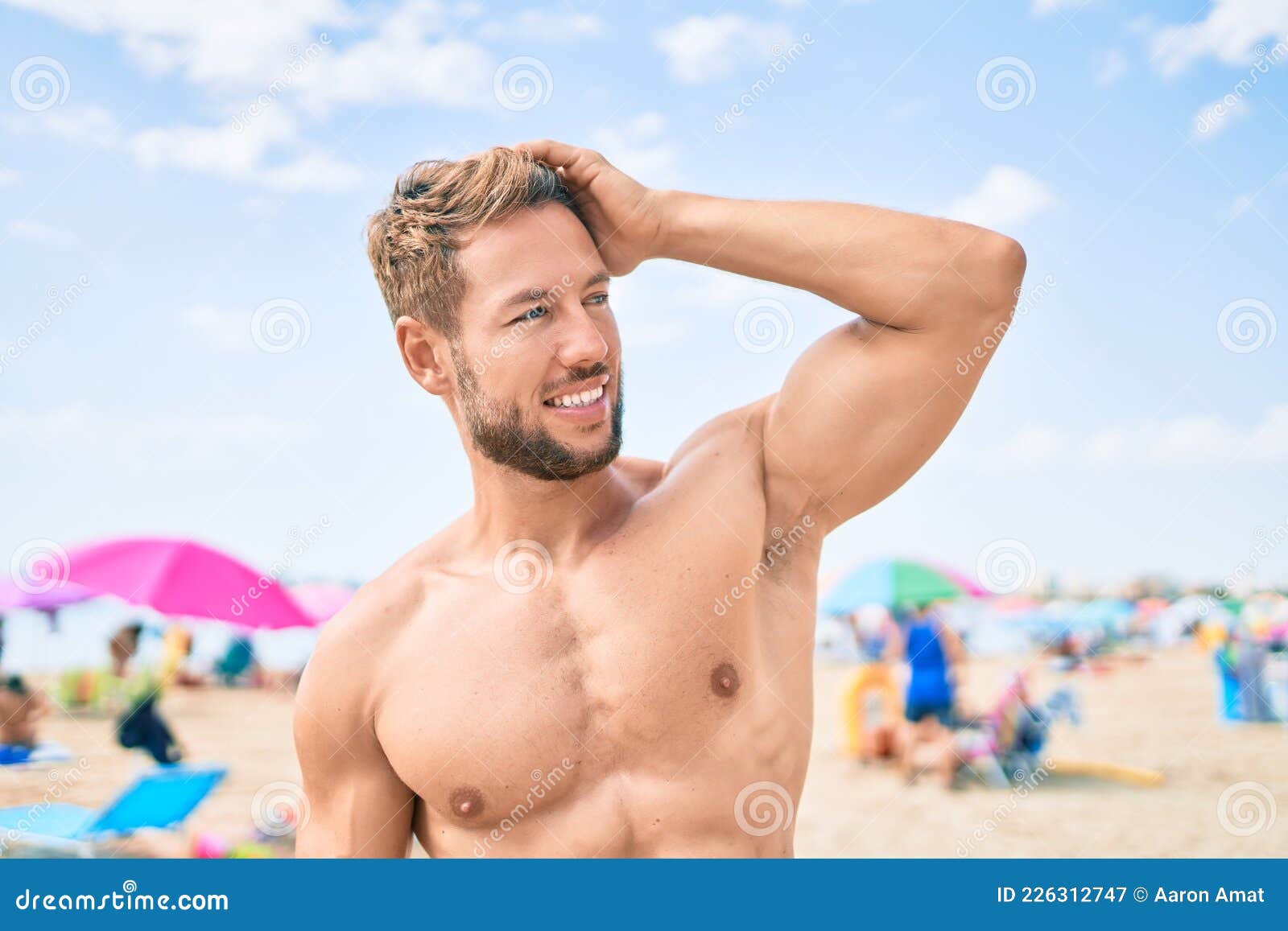 Handsome Fitness Caucasian Man At The Beach On A Sunny Day Showing