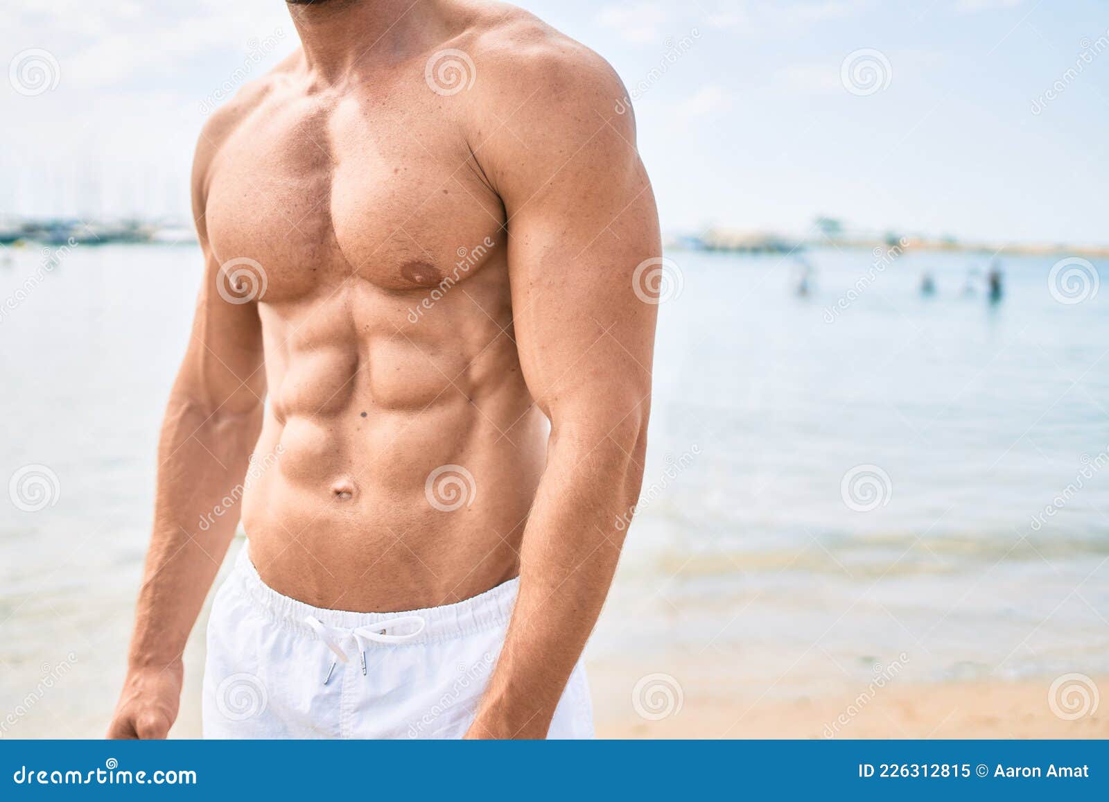 Handsome Fitness Caucasian Man At The Beach On A Sunny Day Showing