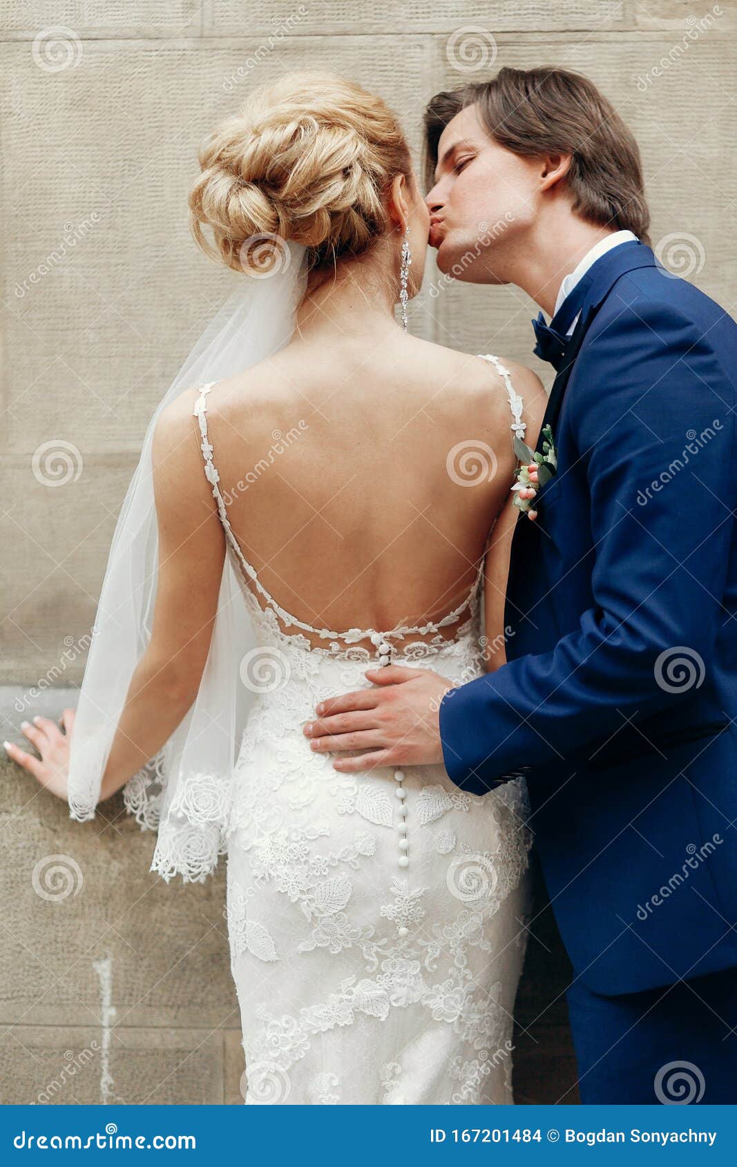Handsome Groom In Blue Suit Sensually Kissing Gorgeous Bride In Luxury