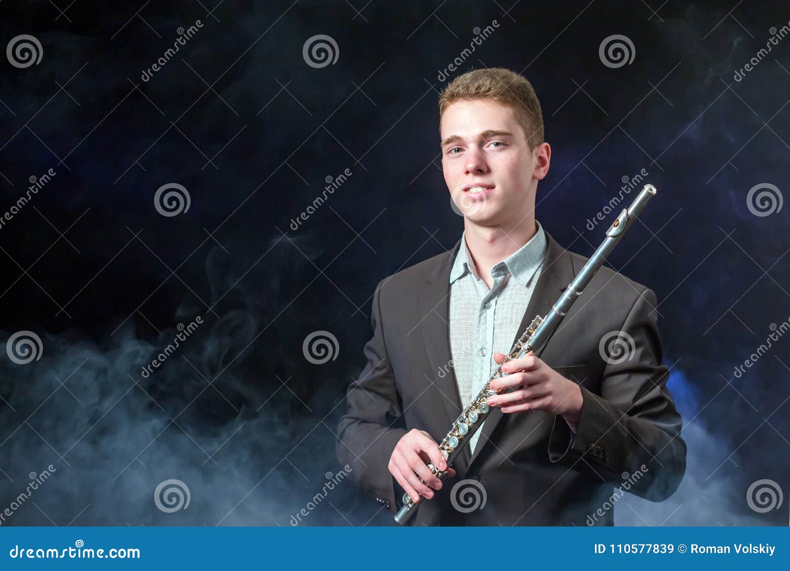 A Handsome Guy in a Gray Jacket Holds a Flute in His Hands. Copy Space ...