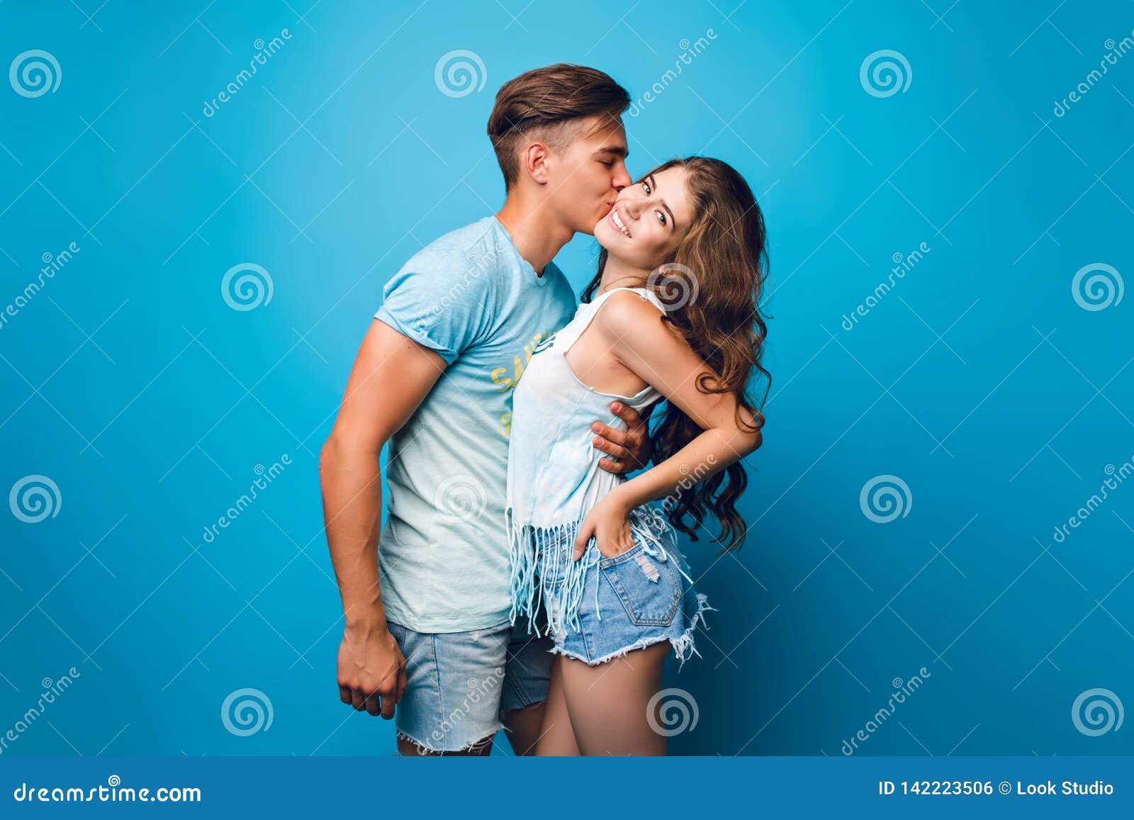 Handsome Guy Is Hugging Pretty Girl With Long Hair And Kissing Her In