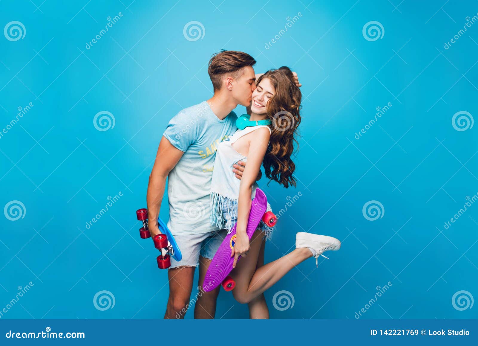 Handsome Guy Is Hugging Pretty Girl With Long Hair And Kissing Her In
