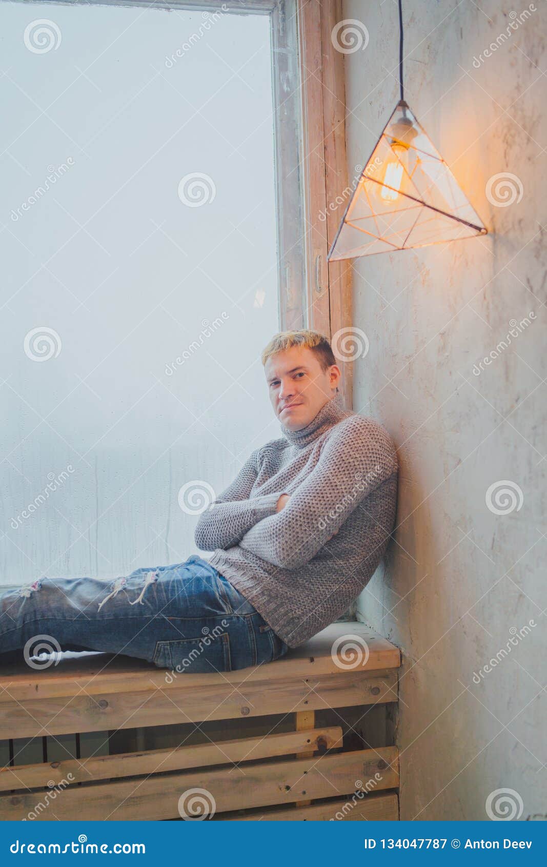 Handsome Guy Sitting on the Windowsill on the Background of a Large ...