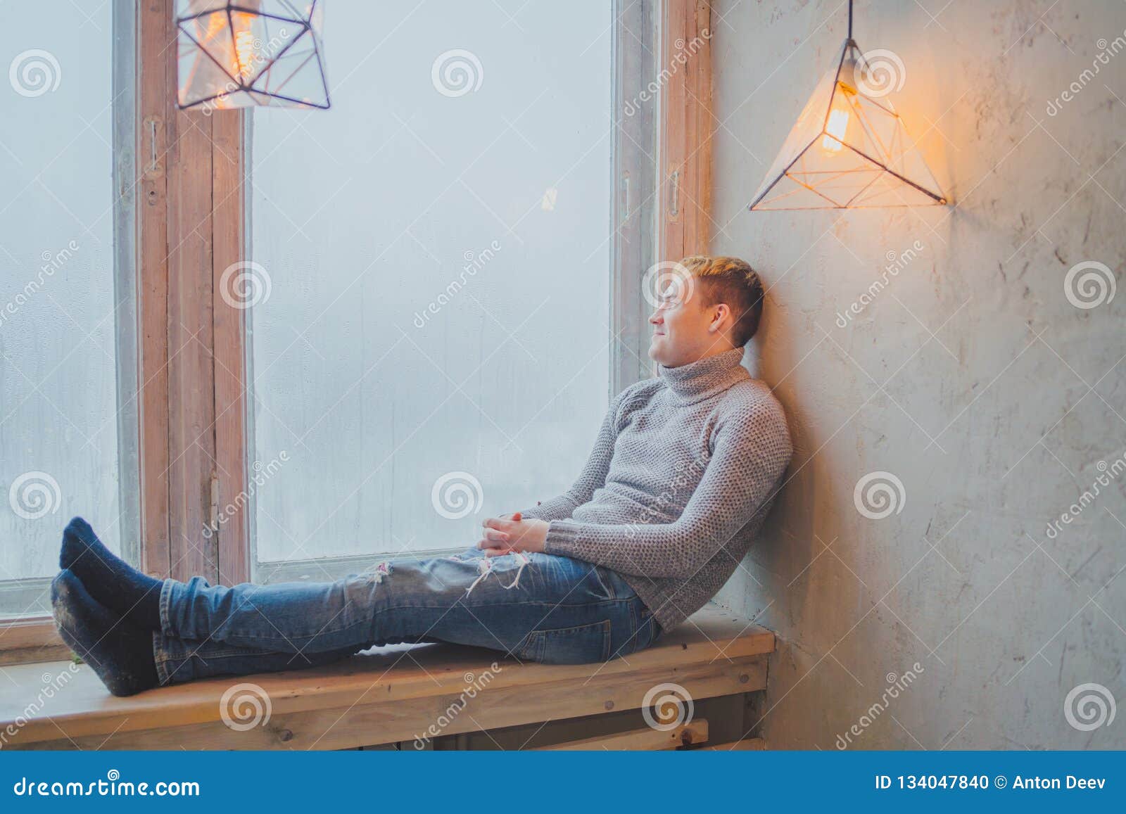 Handsome Guy Sitting on the Windowsill on the Background of a Large ...