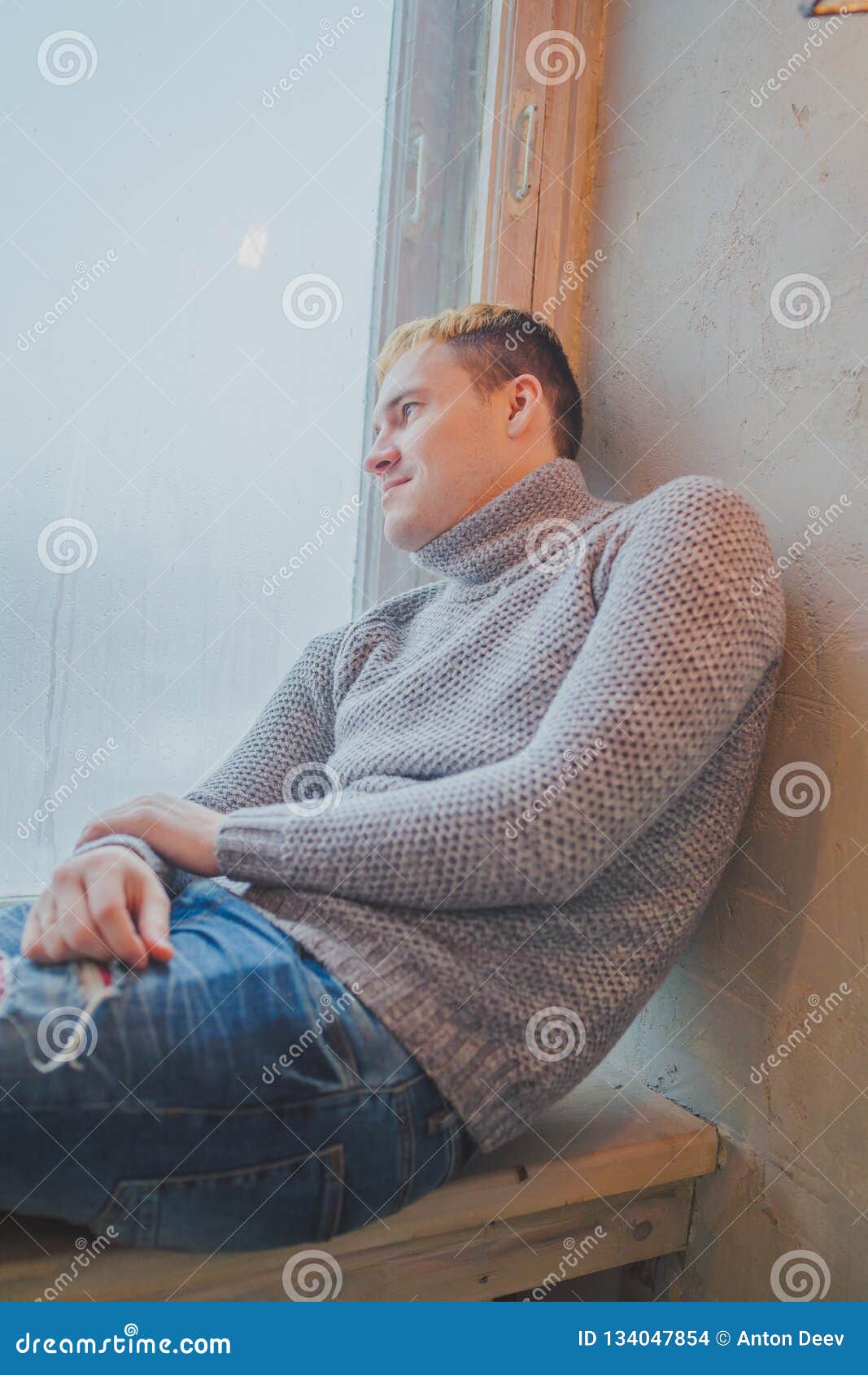 Handsome Guy Sitting on the Windowsill on the Background of a Large ...