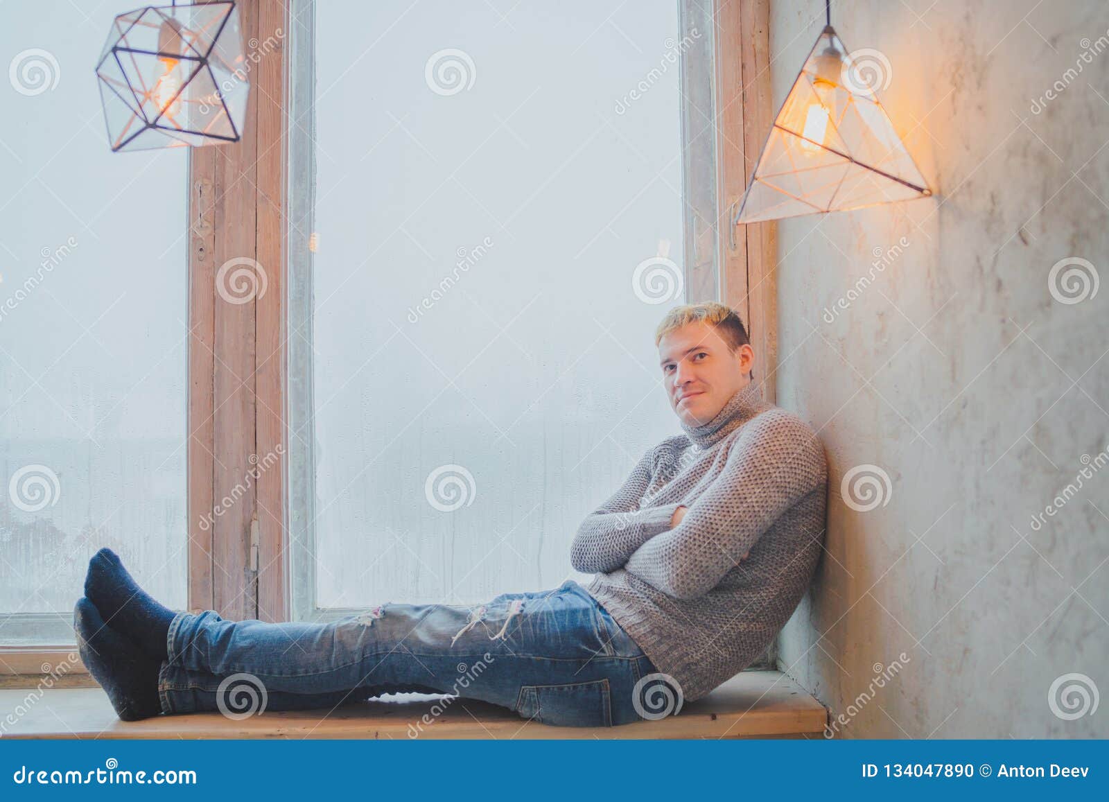 Handsome Guy Sitting on the Windowsill on the Background of a Large ...