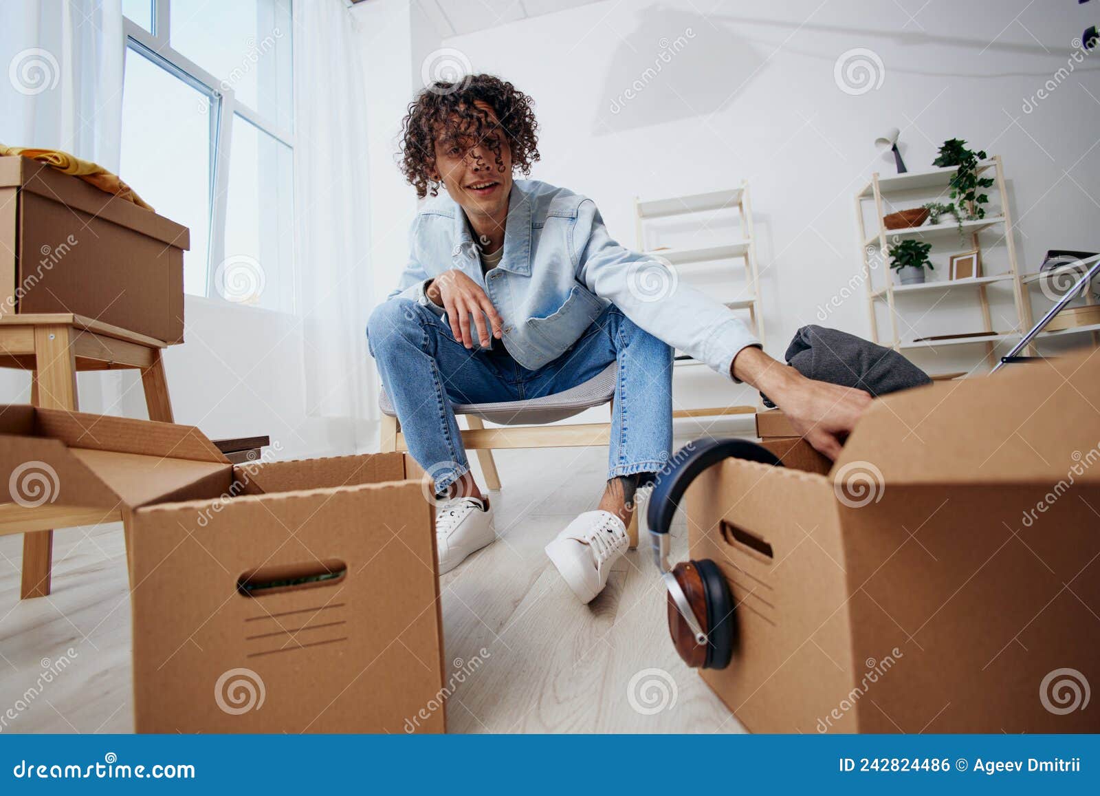 Handsome Guy Unpacking Things from Boxes in the Room Sorting Things Out ...