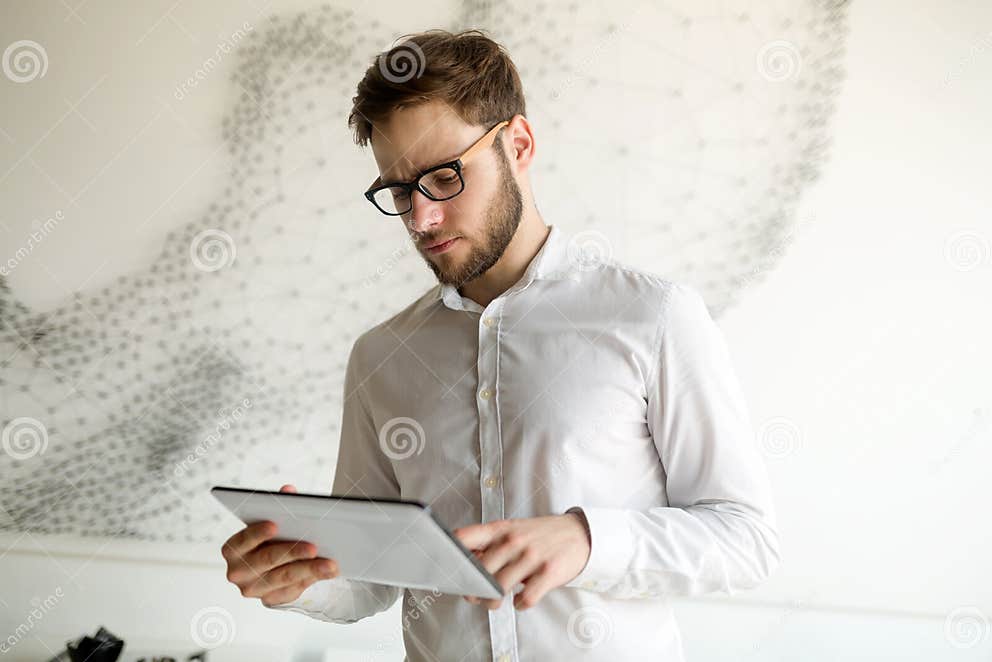 Handsome guy using tablet stock photo. Image of male - 128937960