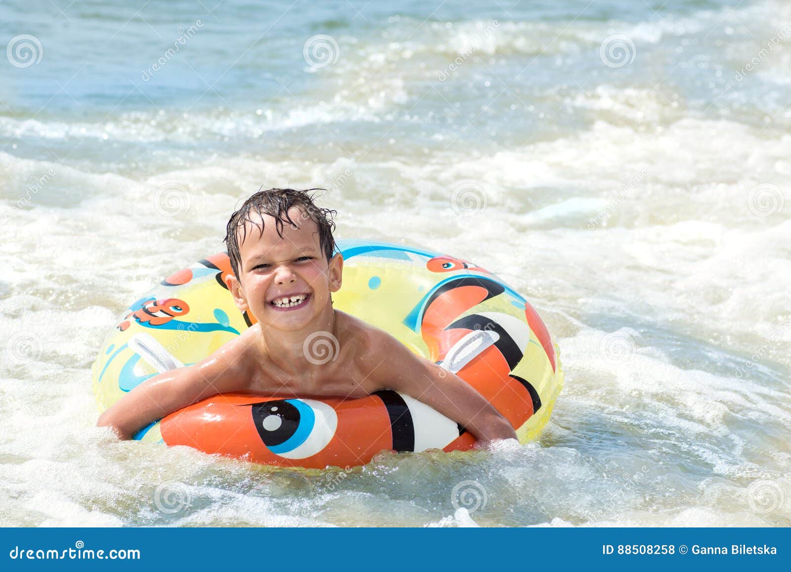 Handsome Happy Boy with Inflatable Ring Floating on the Sea, Waves and ...