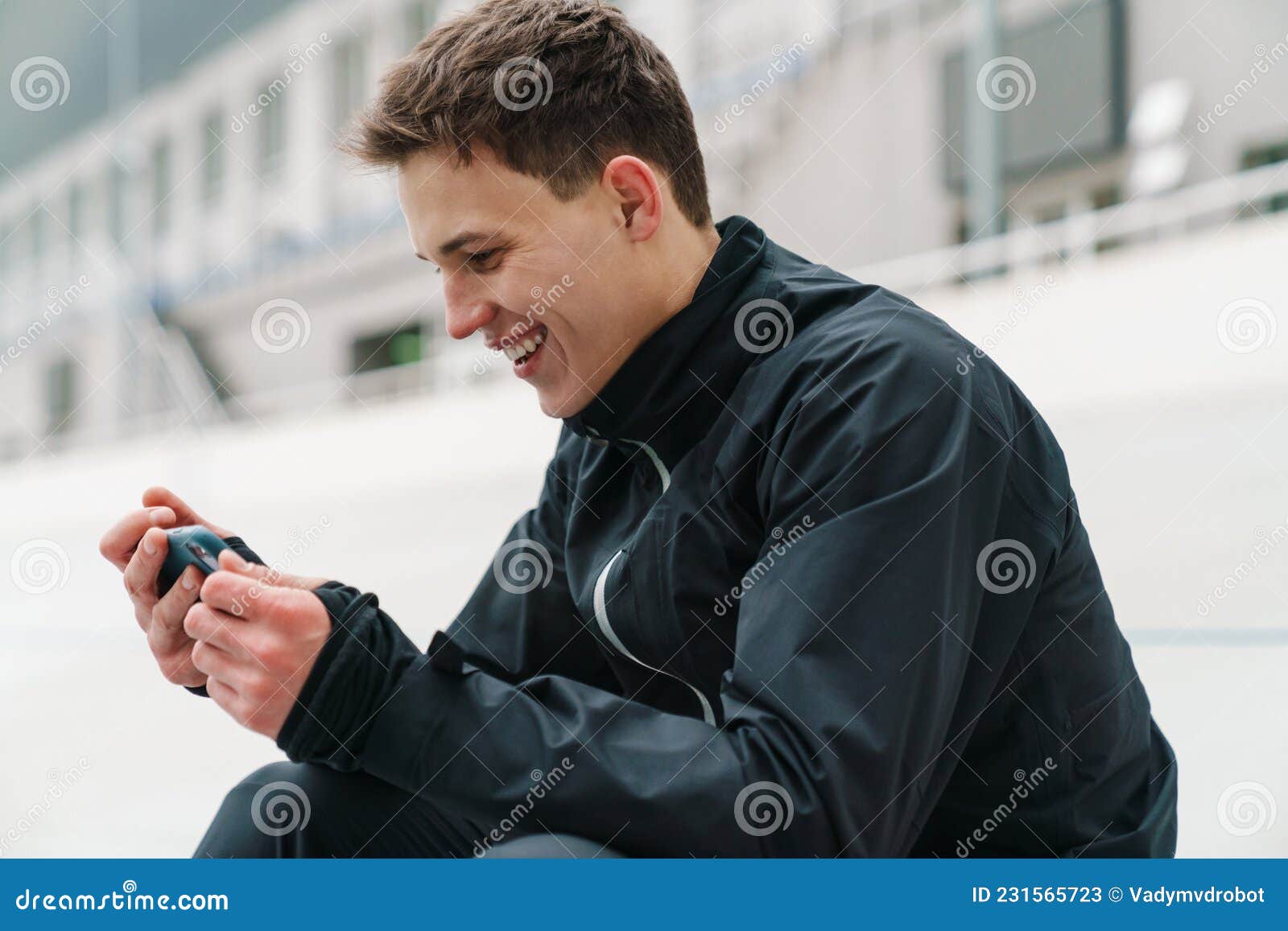 Handsome Happy Sportsman Using Mobile Phone while Sitting at Stadium ...