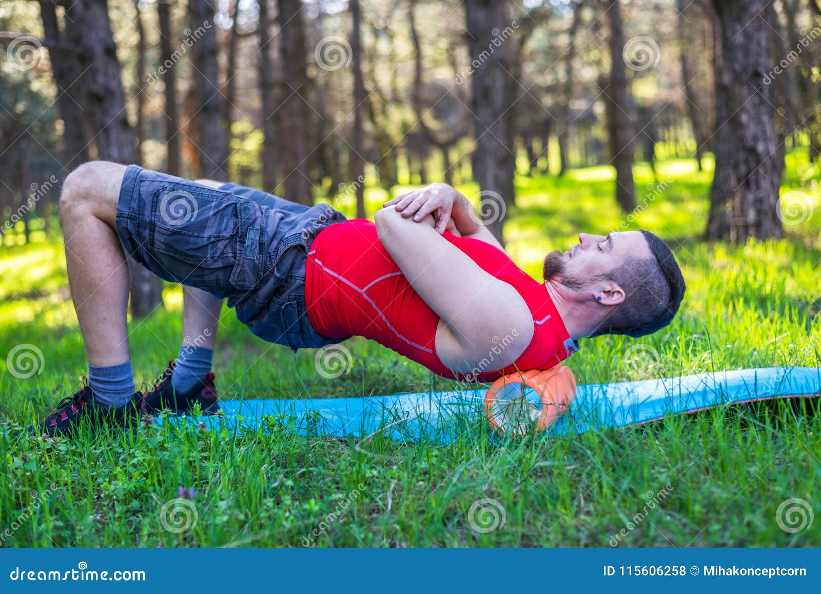 Handsome Healthy Man Doing an Exercise on a Mat with Foam Roller on His ...