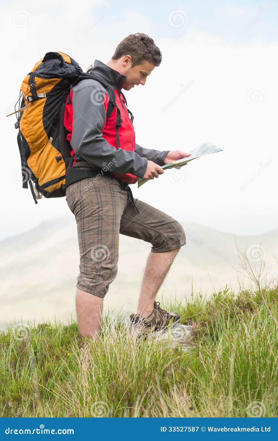 Handsome Hiker with Backpack Walking Uphill Reading a Map Stock Image ...