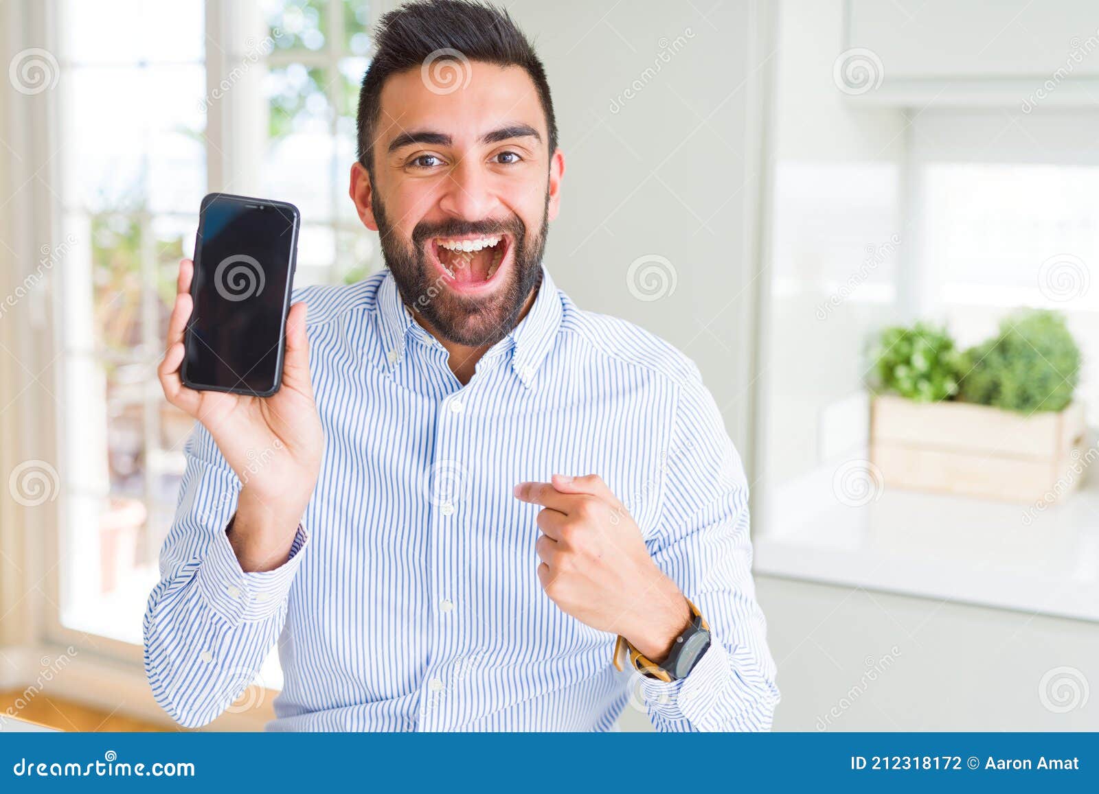 Handsome Hispanic Business Man Showing Smartphone Screen with Surprise ... Handsome Hispanic Business Man Showing Smartphone Screen with Surprise ...