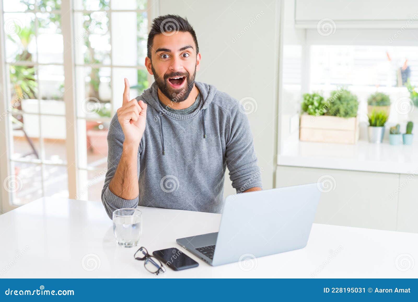 Handsome Hispanic Man Working Using Computer Laptop Surprised with an ...