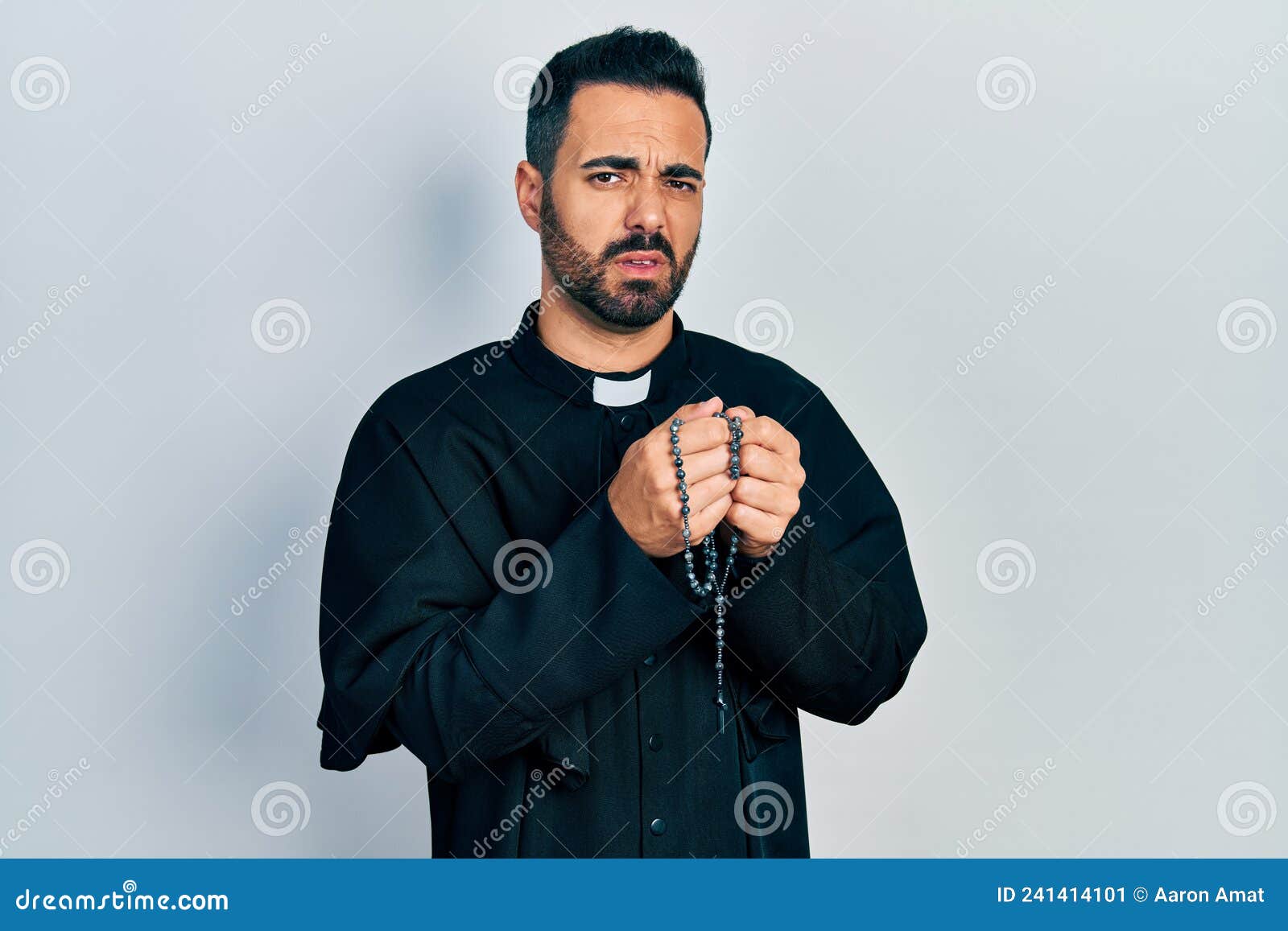 Handsome Hispanic Priest Man with Beard Praying Holding Catholic Rosary ...