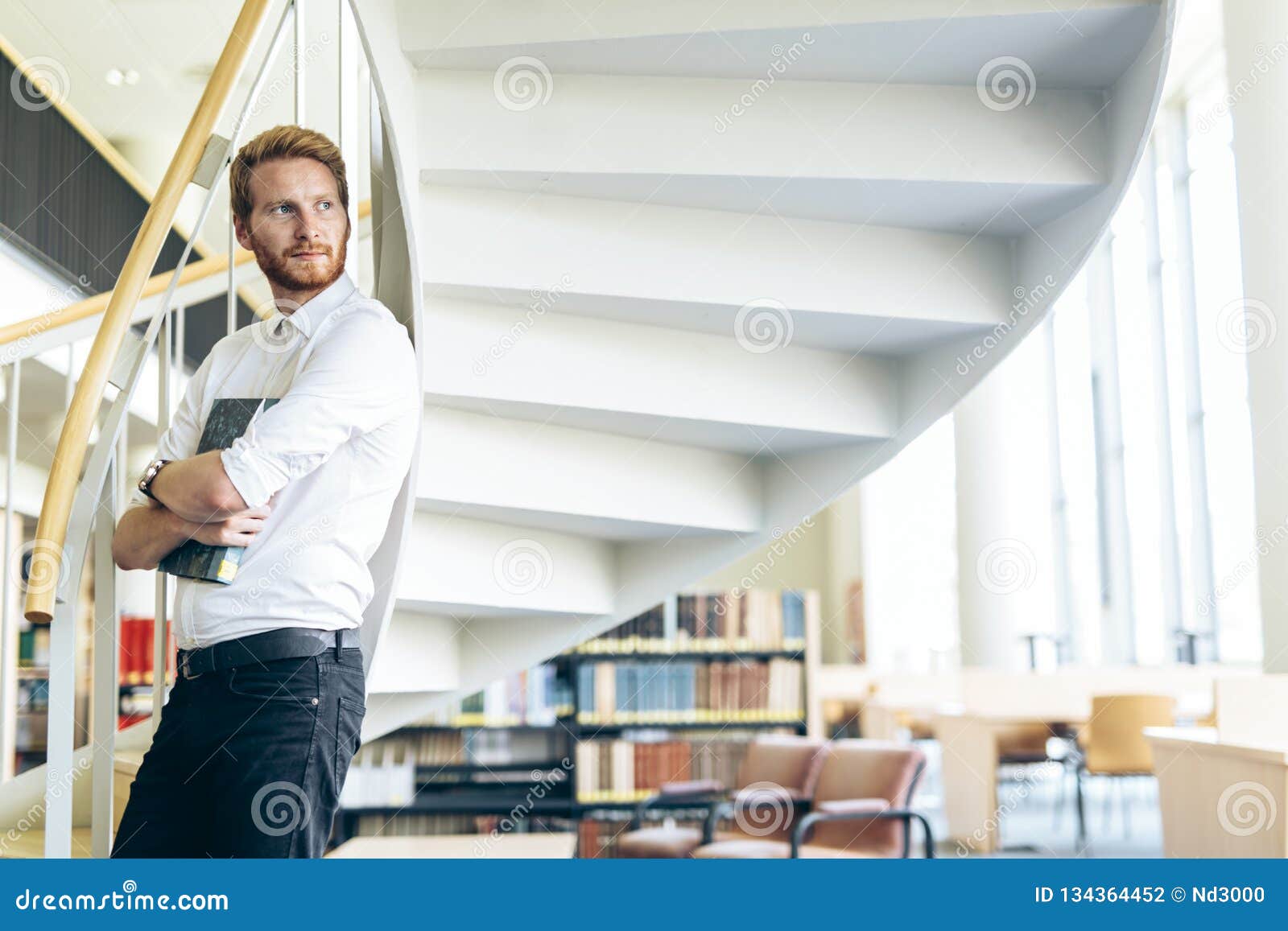 Handsome Intelligent Guy Reading a Book in a Library Stock Photo ...