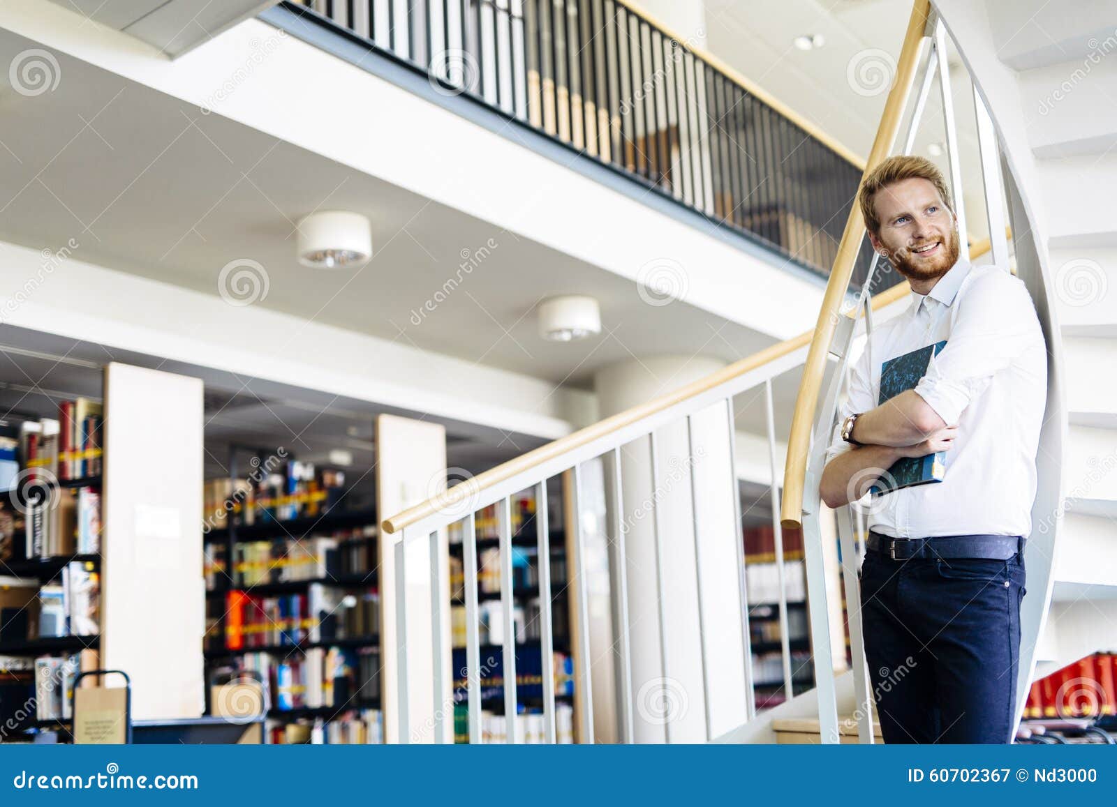 Handsome Intelligent Guy Reading a Book in a Library Stock Image ...