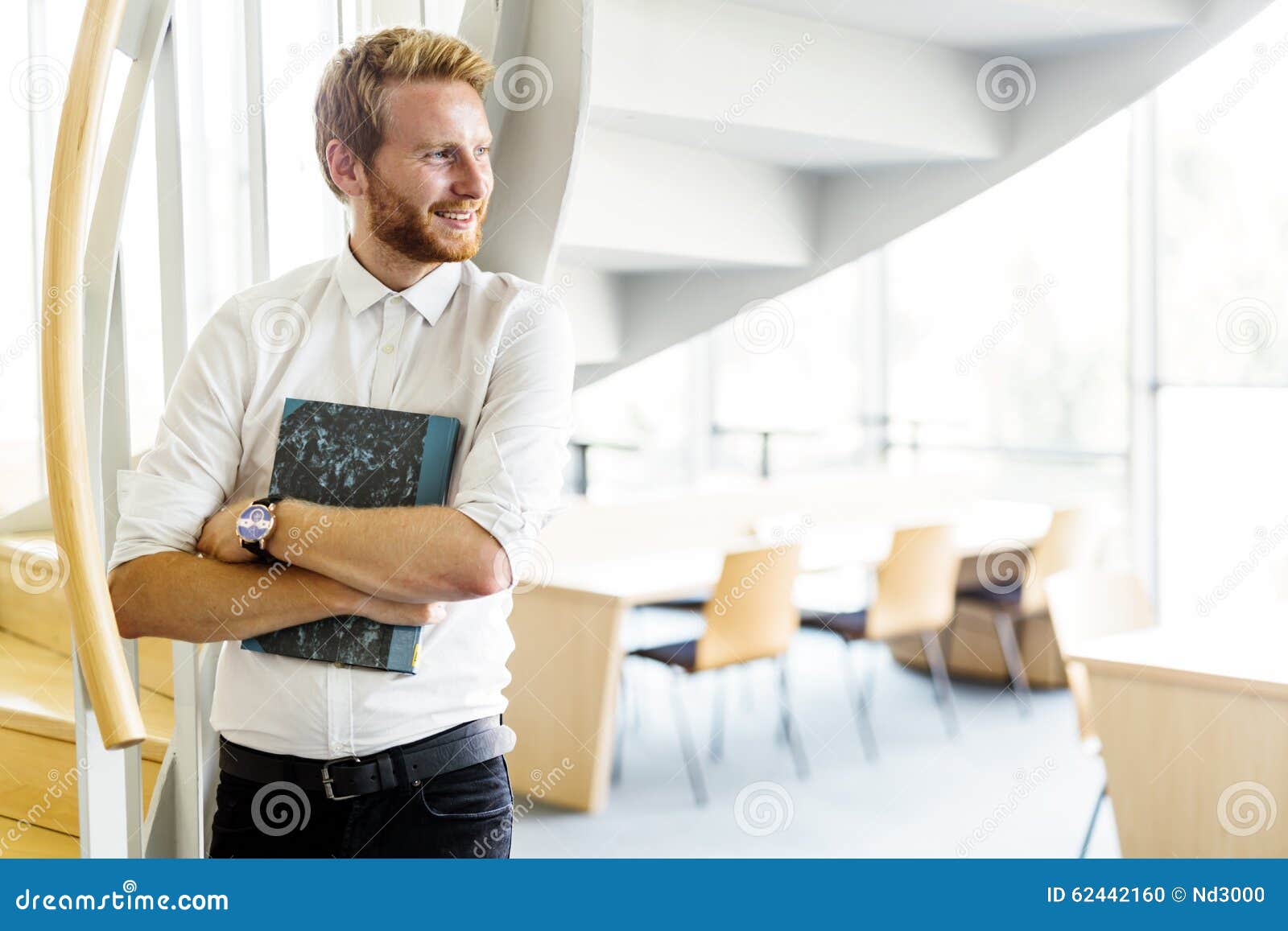 Handsome Intelligent Guy Reading a Book in a Library Stock Photo ...