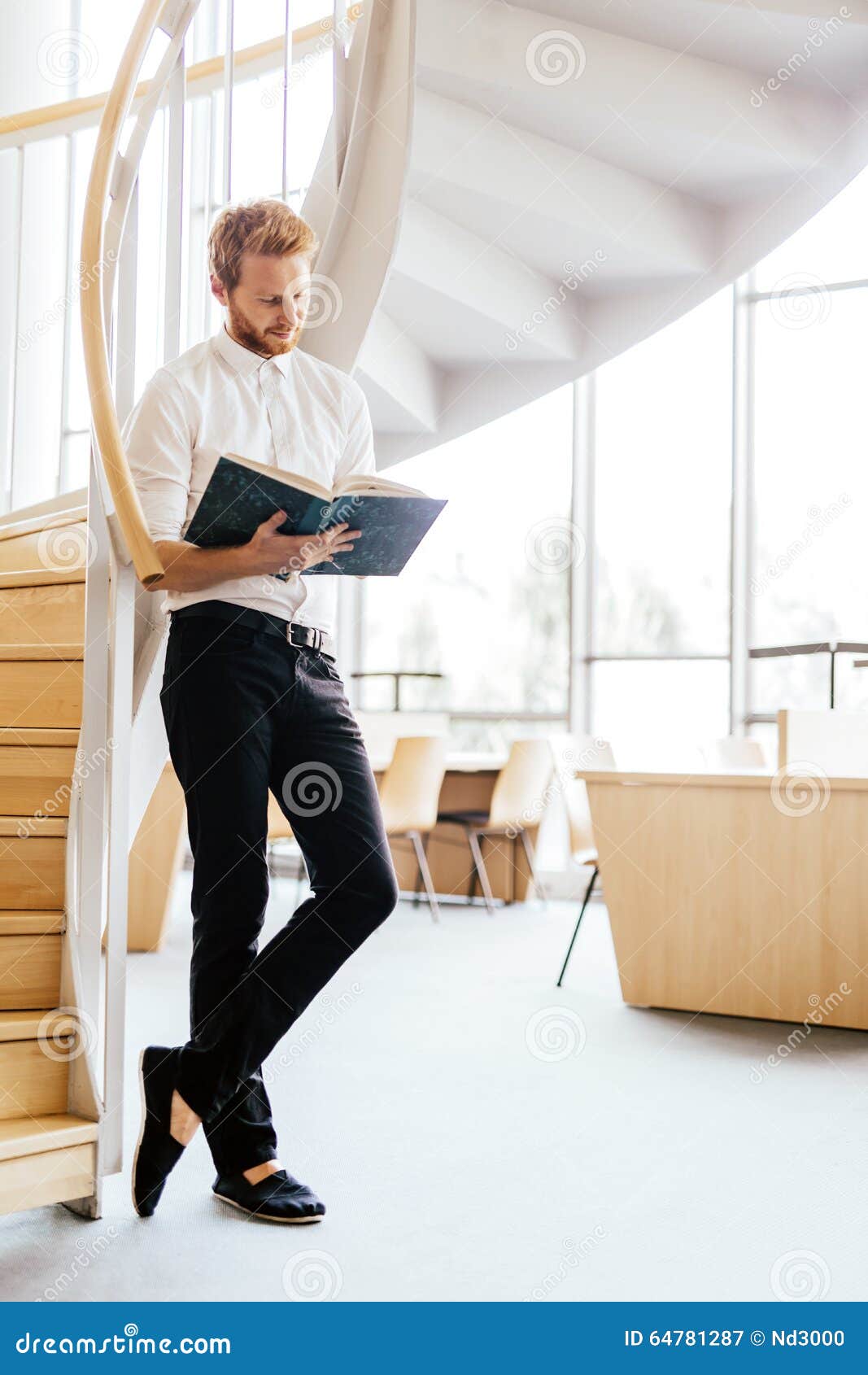 Handsome Intelligent Guy Reading a Book in a Library Stock Image ...