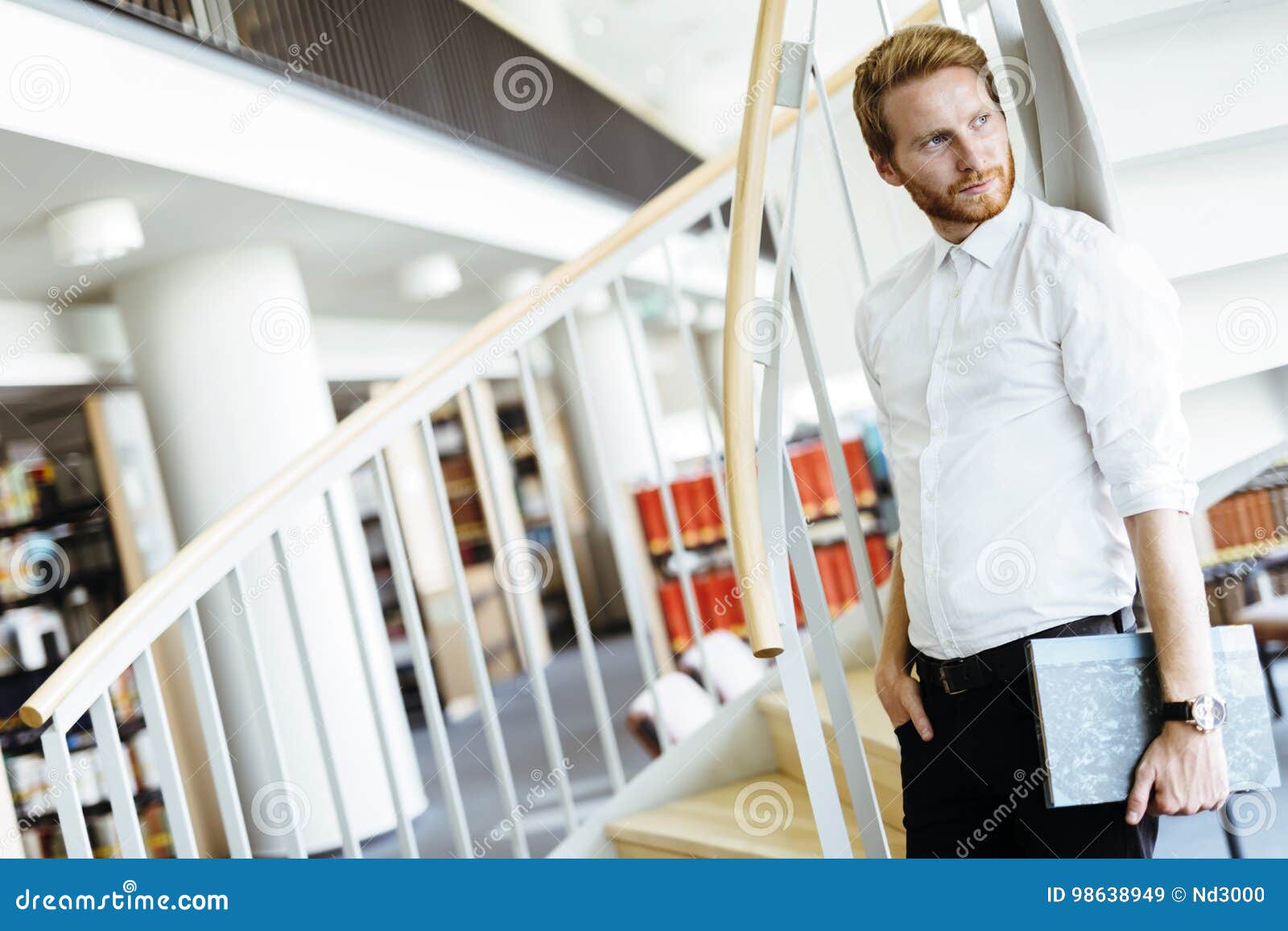 Handsome Intelligent Guy Reading a Book in a Library Stock Image ...