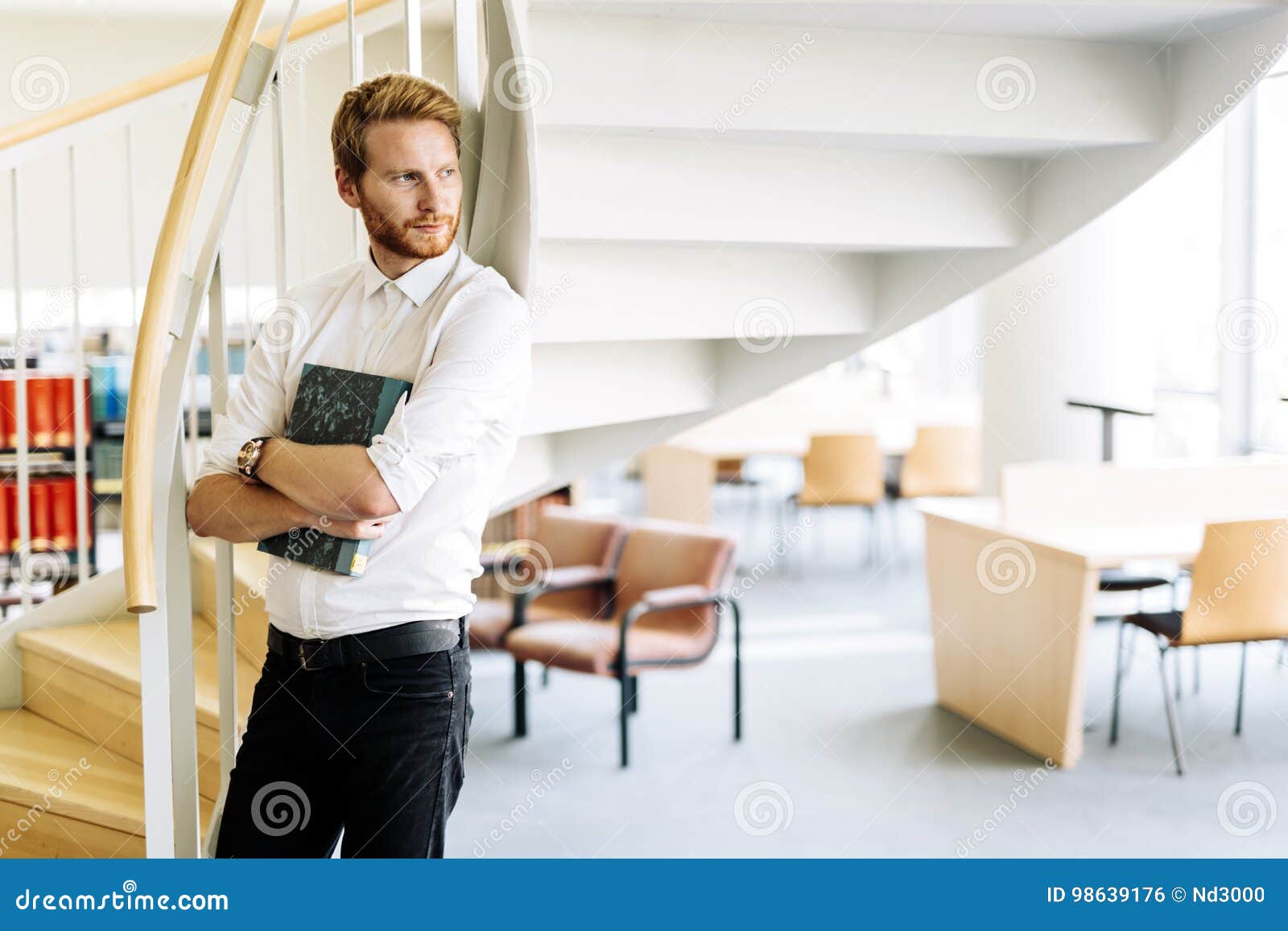 Handsome Intelligent Guy Reading a Book in a Library Stock Photo ...