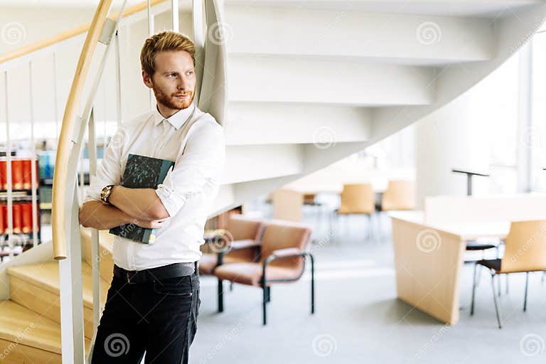 Handsome Intelligent Guy Reading a Book in a Library Stock Photo ...