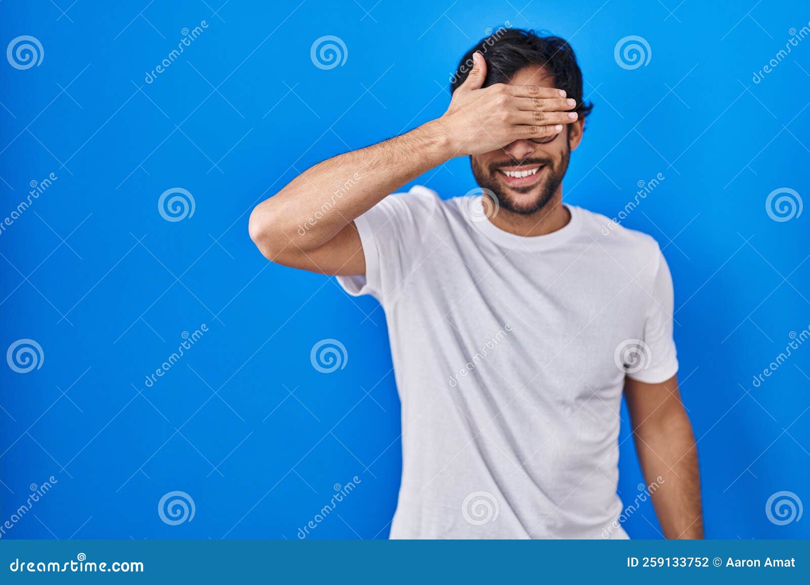 Handsome Latin Man Standing Over Blue Background Smiling And Laughing