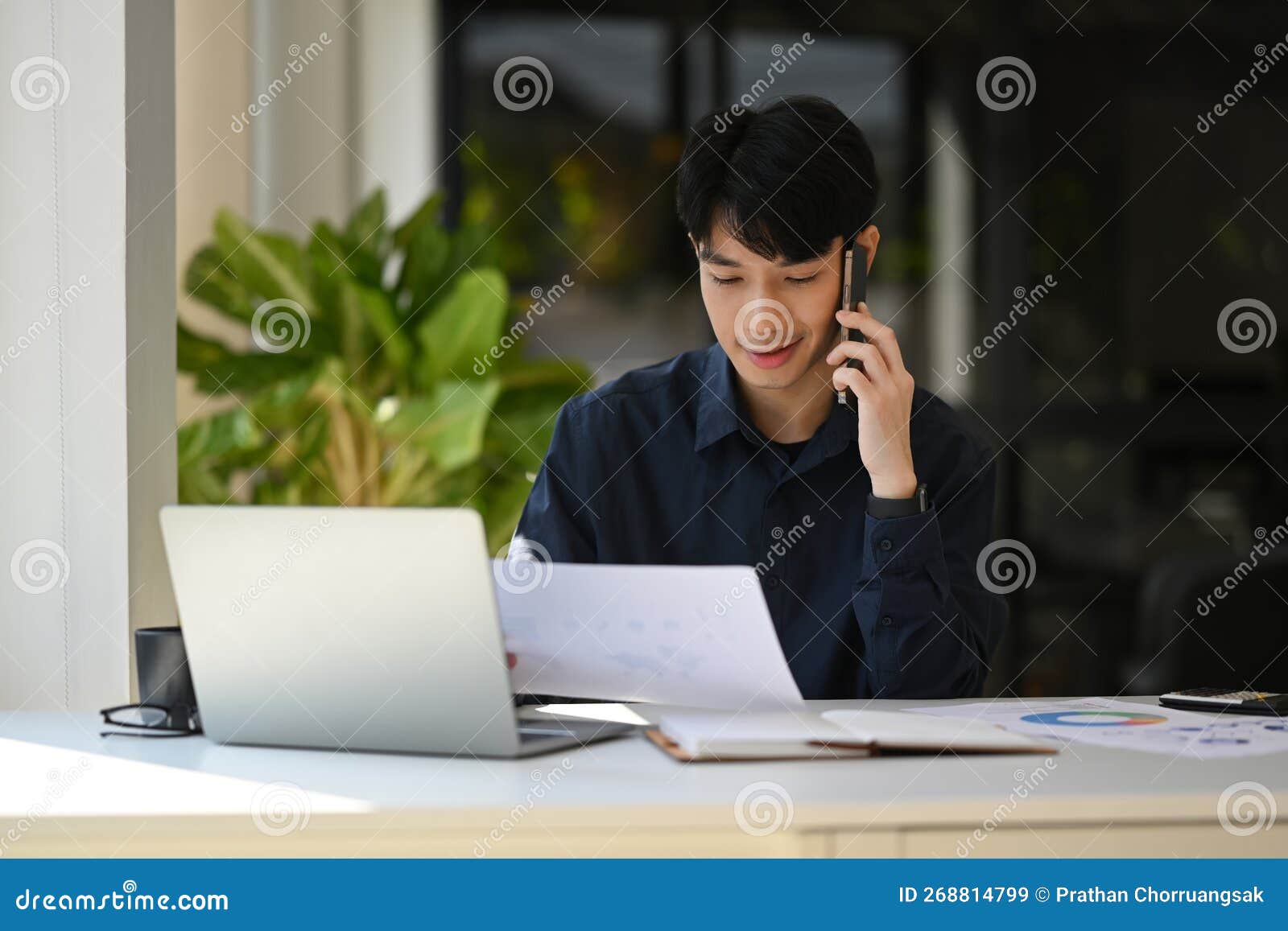 Handsome Male Financial Advisor Looking at Document and Talking on ...
