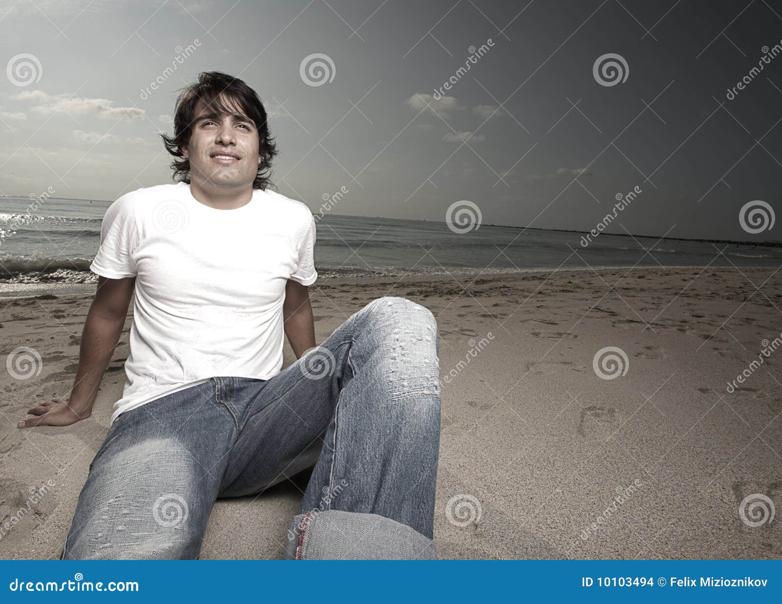 Handsome Male Sitting on the Sand Stock Photo - Image of jeans, young ...