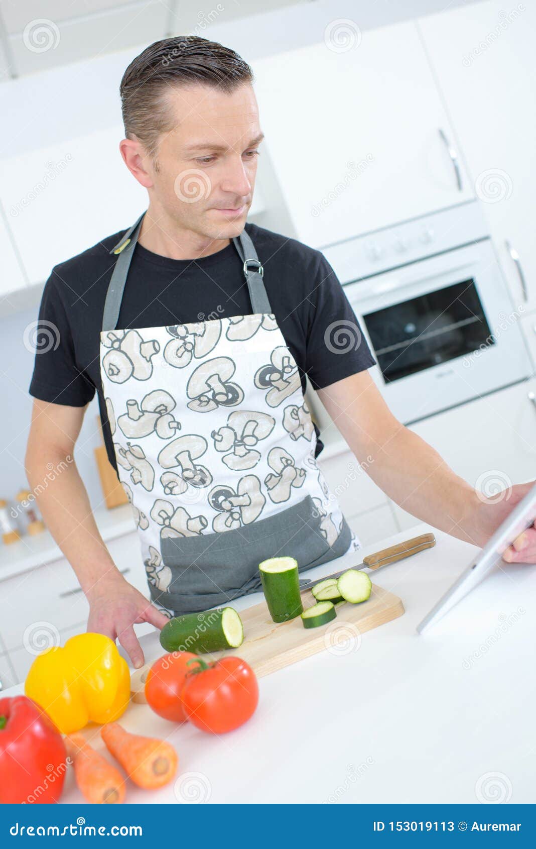 Handsome Man Cooking at Home while Checking Tablet Stock Image - Image ...