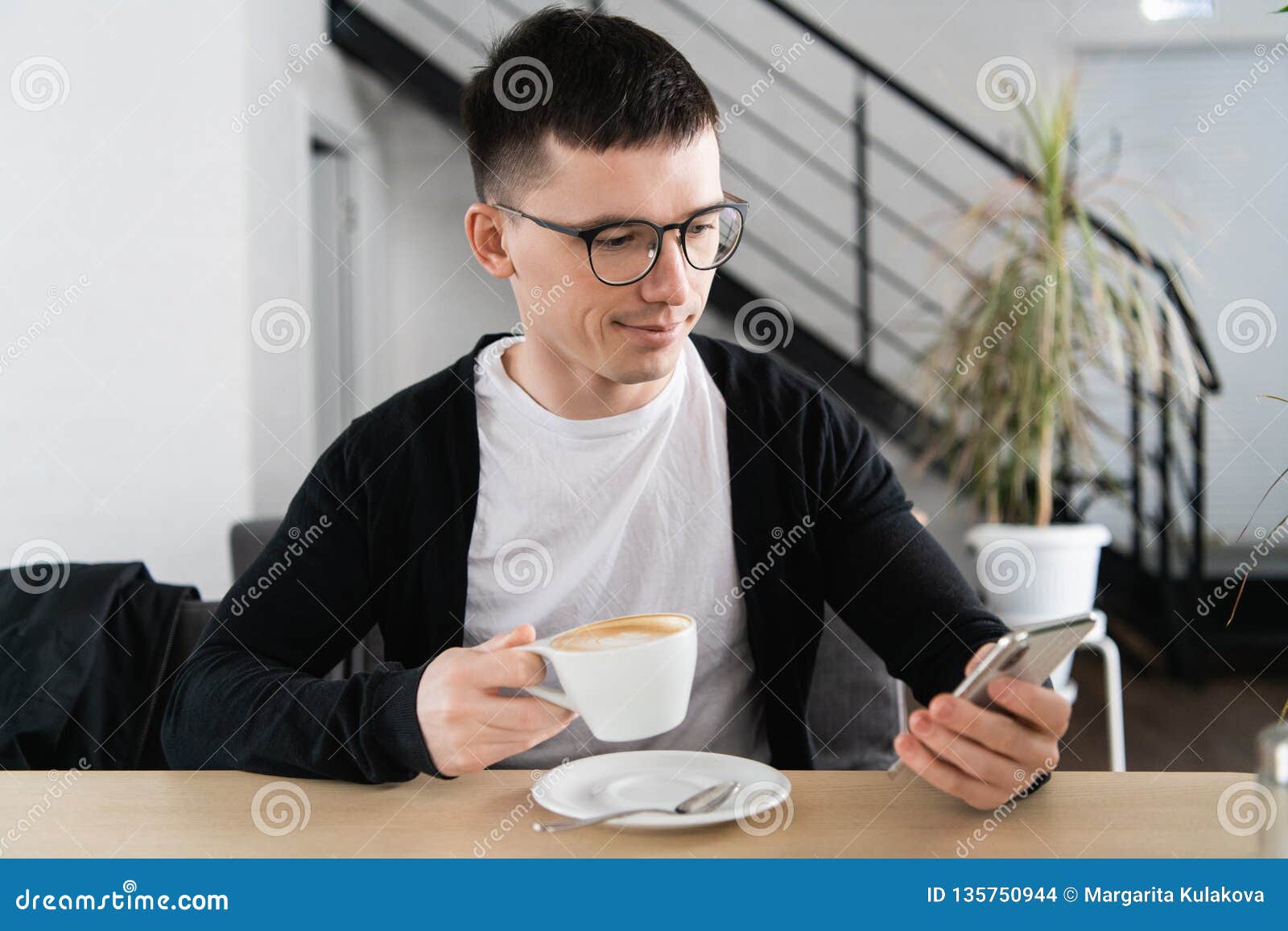 Handsome Man Having Coffee and Using Smartphone at Coffee Shop Stock ...