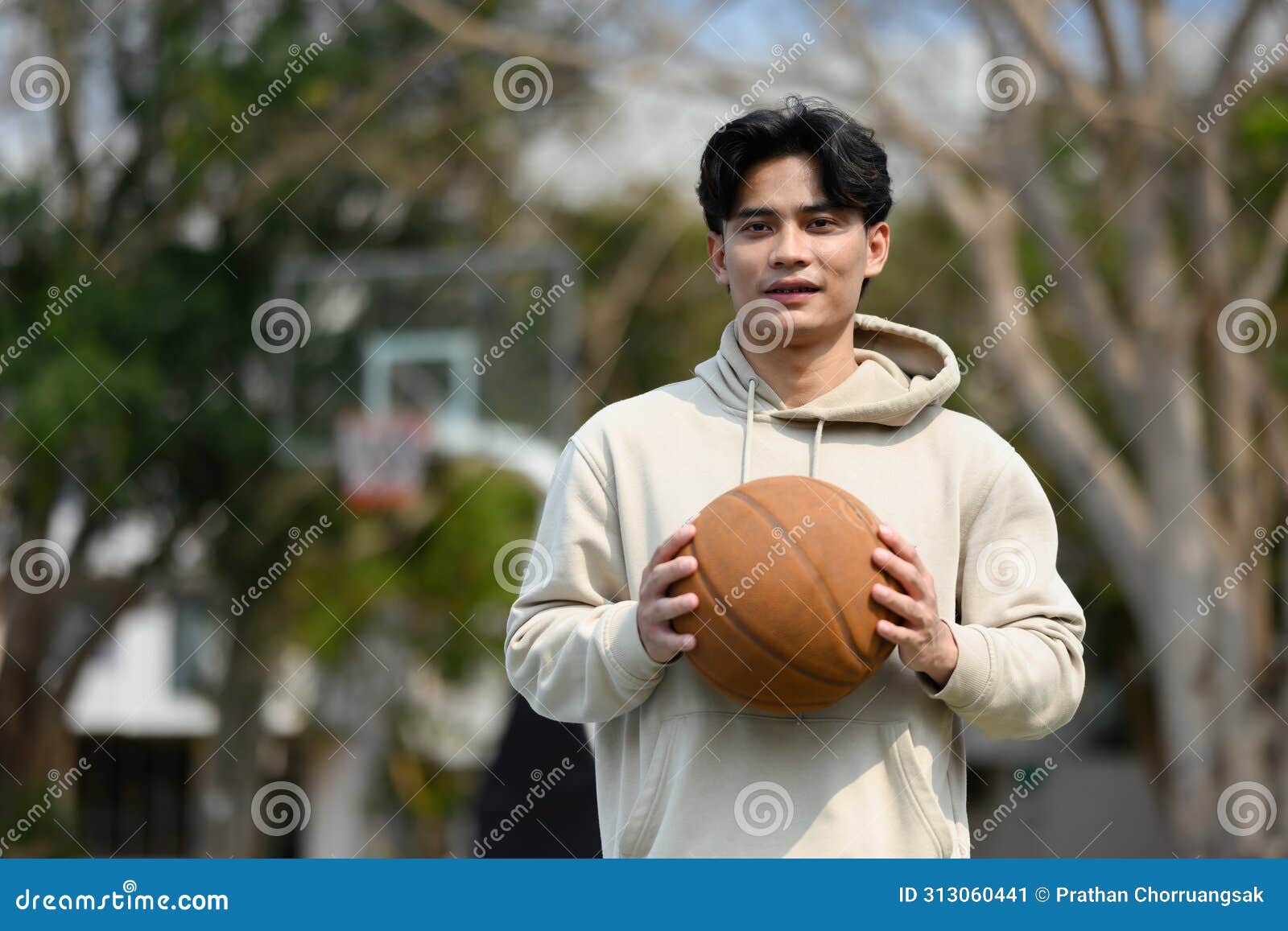 Handsome Man Holding Ball with Both Hands and Smiling at Camera ...