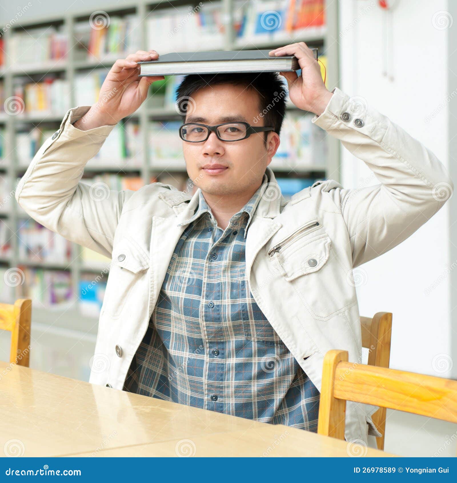 Handsome man in a library stock image. Image of sitting - 26978589