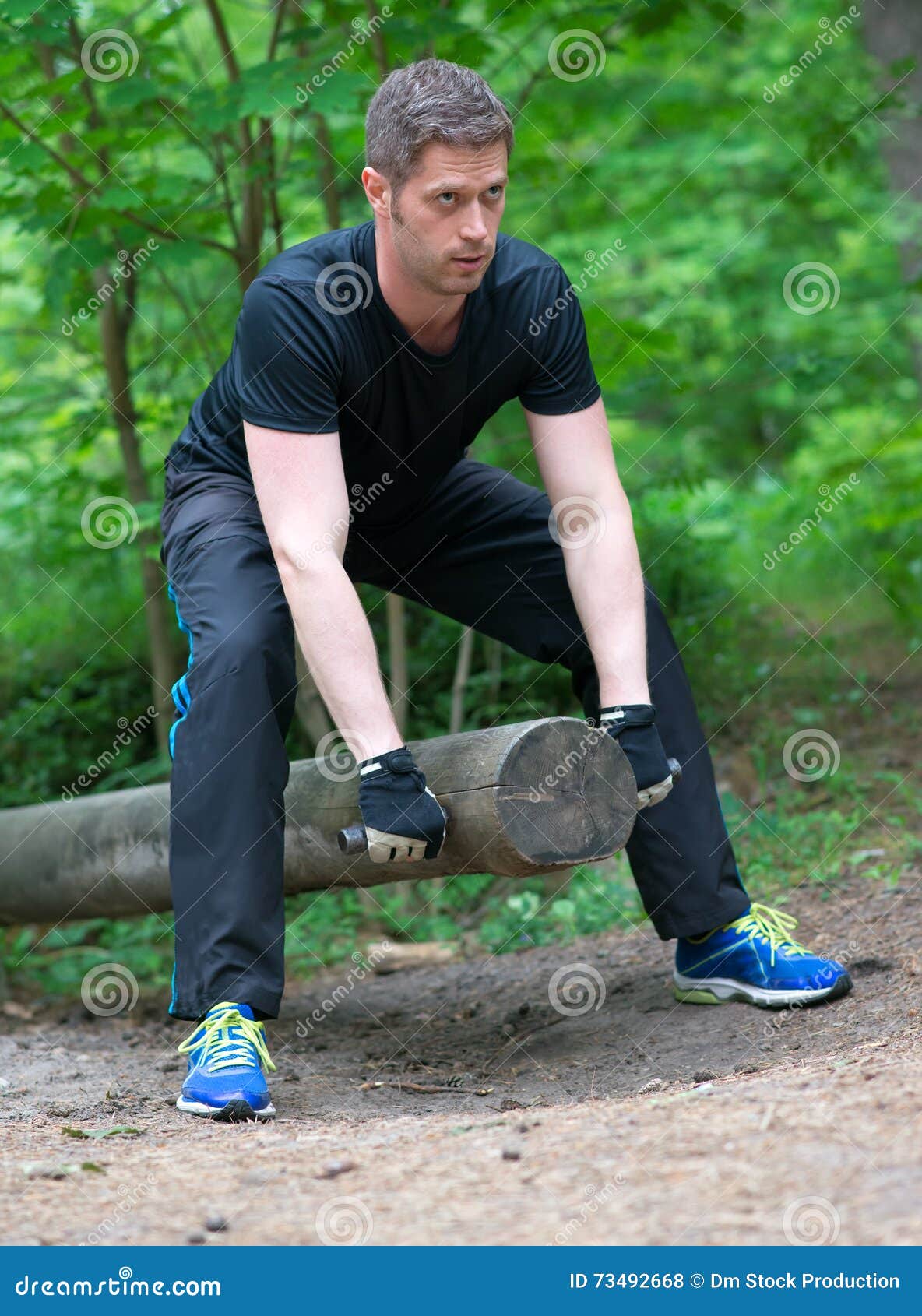 Handsome man lifting log. stock photo. Image of handsome - 73492668