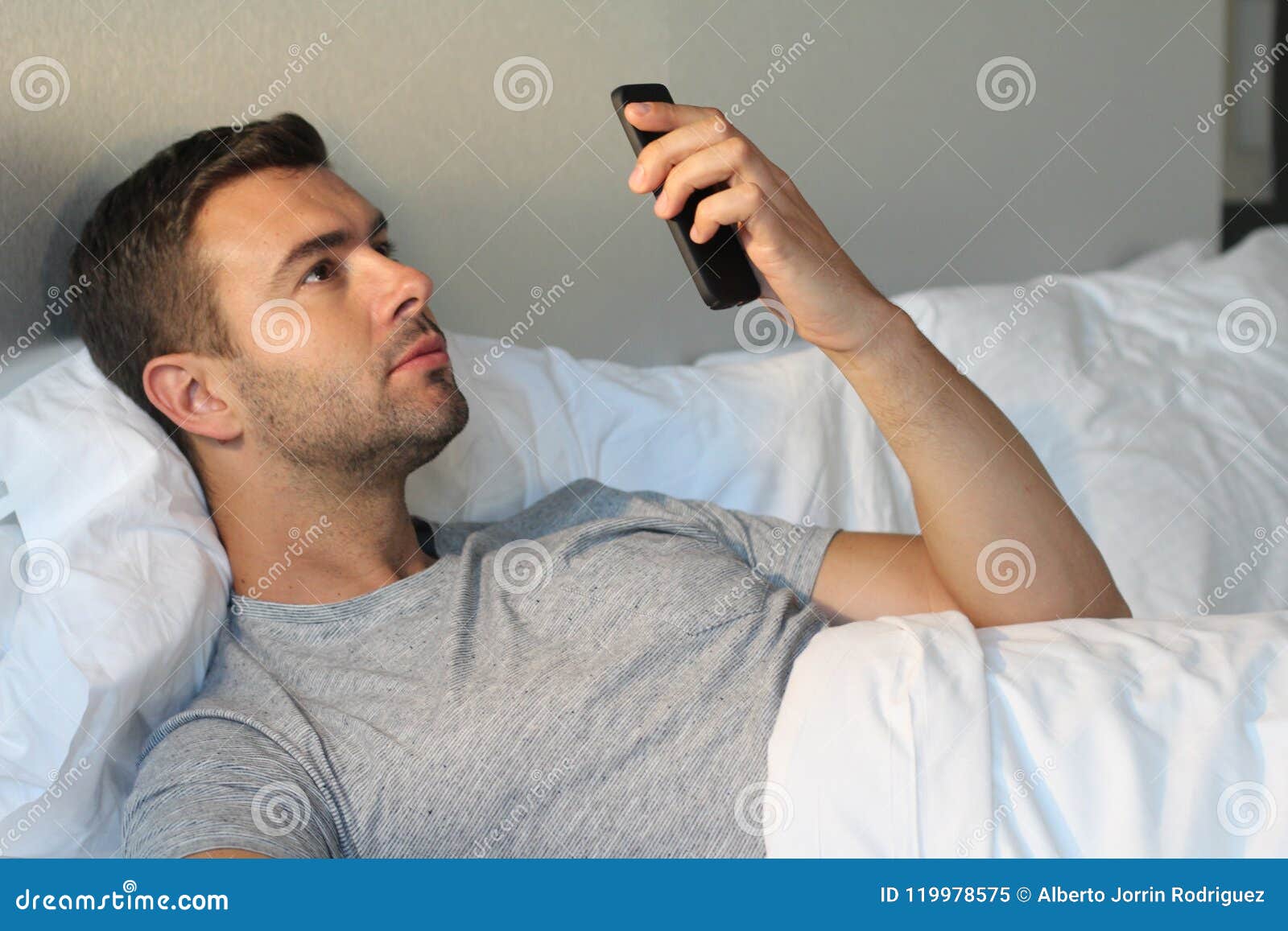 Handsome Man Looking at Phone in Bed Stock Image - Image of bedroom ...