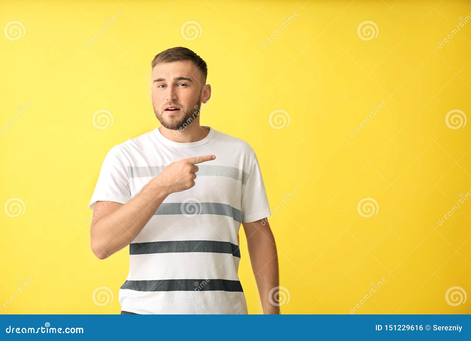 Handsome Man Pointing at Something on Color Background Stock Photo ...