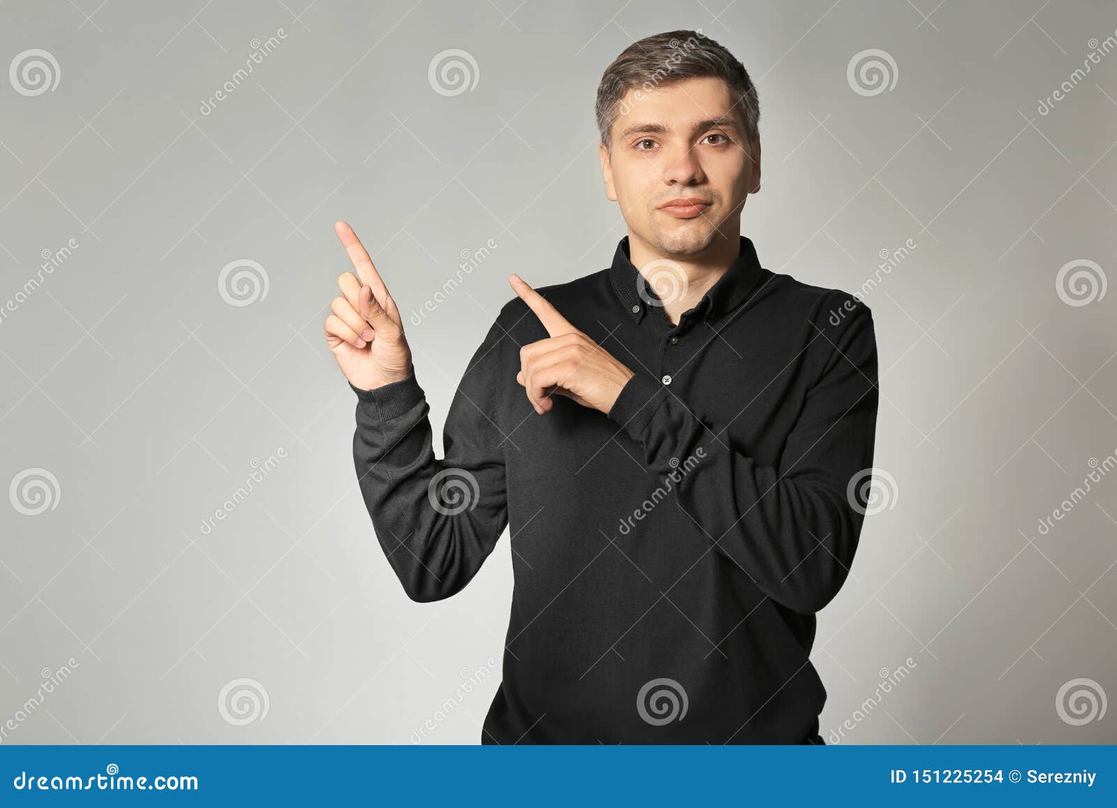 Handsome Man Pointing at Something on Grey Background Stock Photo ...