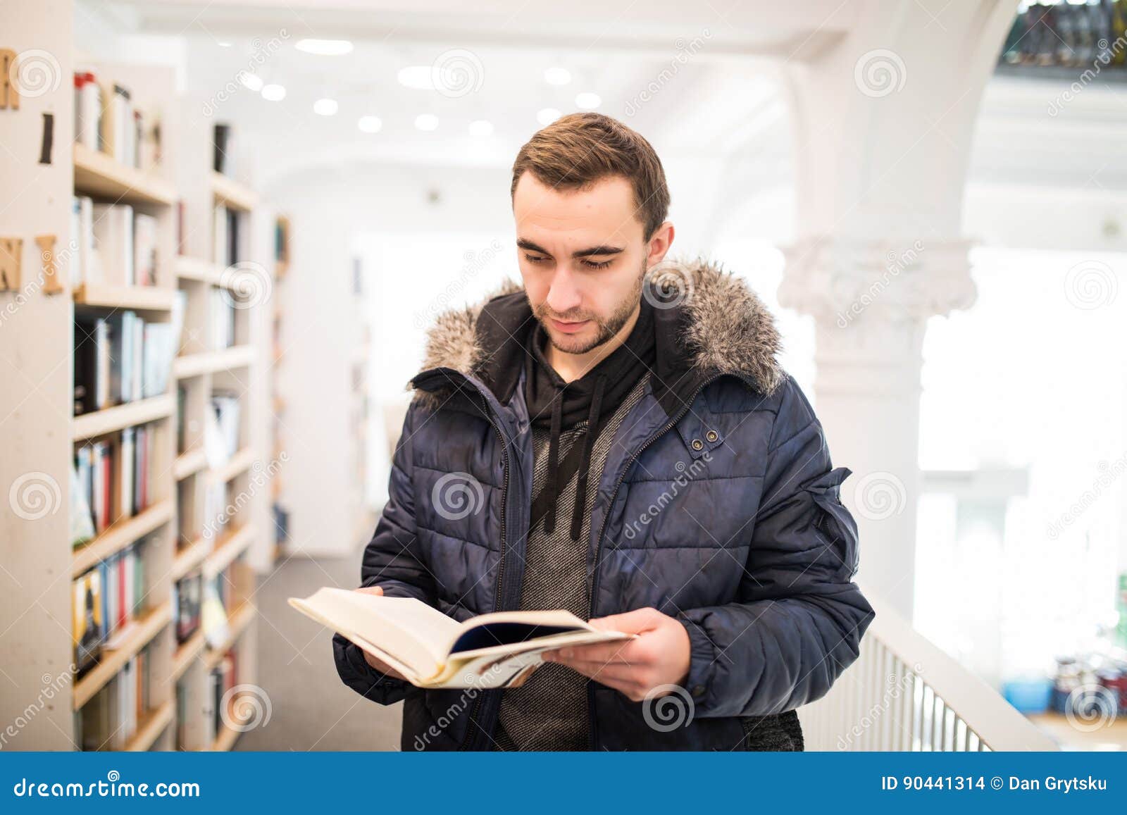Handsome Man Reading a Book in Book Store Wearing in Winter Jacket ...