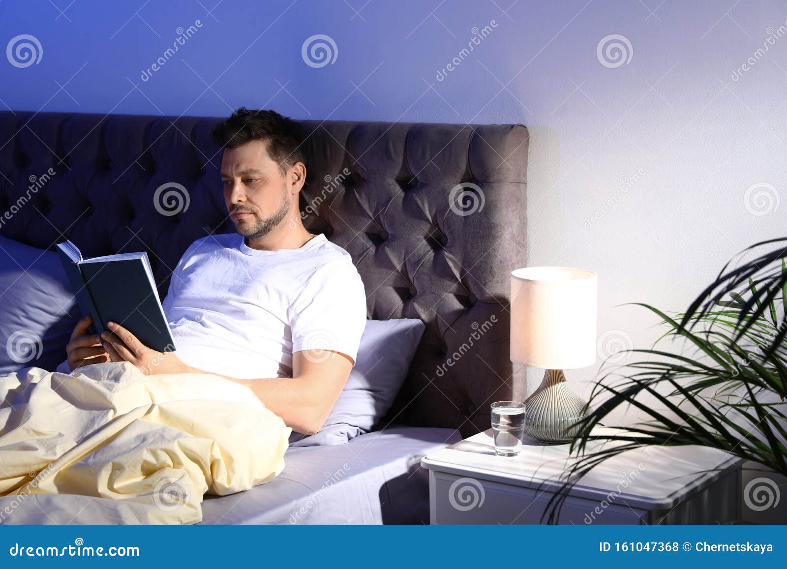 Handsome Man Reading Book in Dark Room at Night Stock Photo - Image of ...