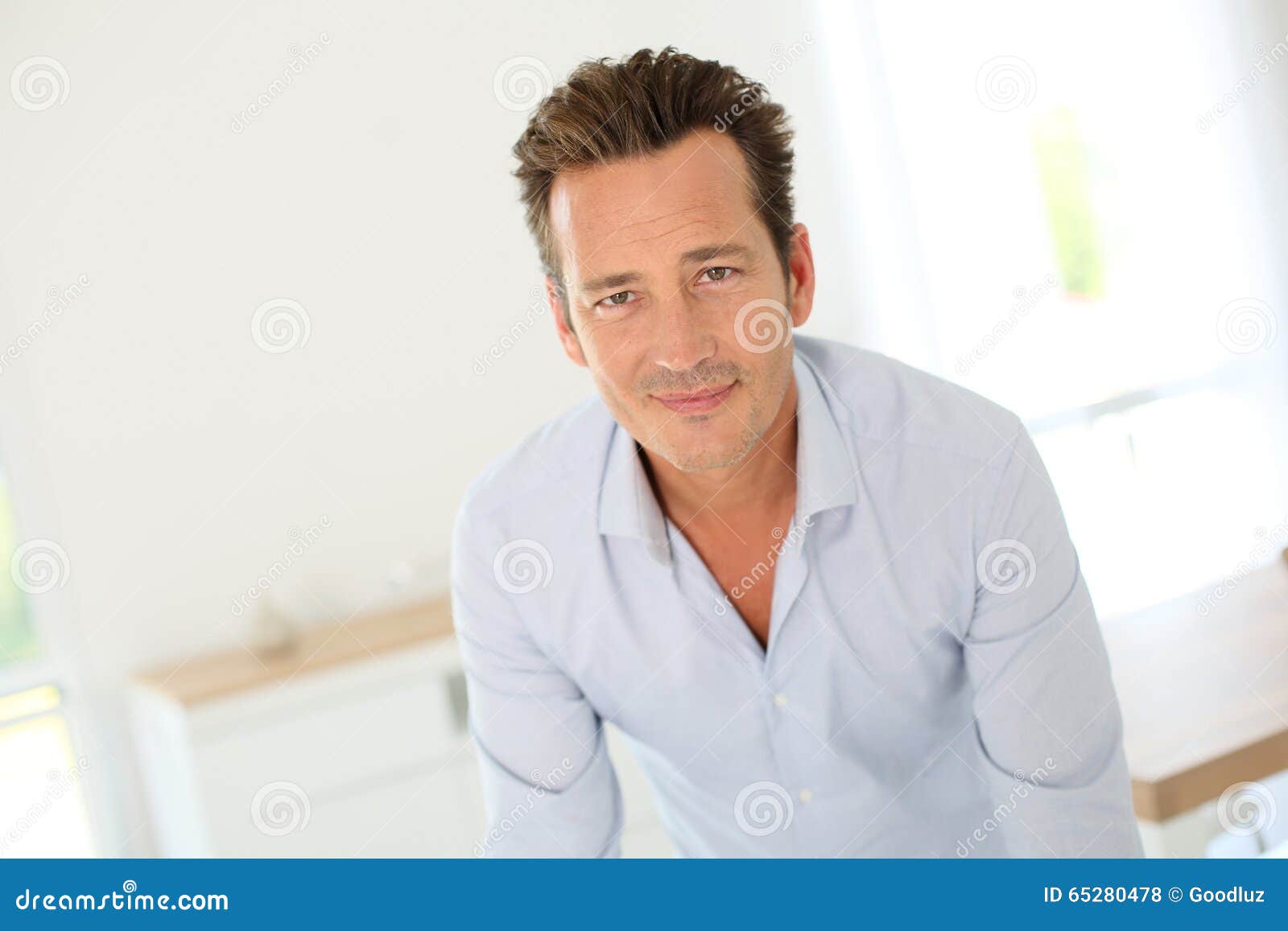 Handsome Man Sitting at Home Stock Photo - Image of looking, smiling ...