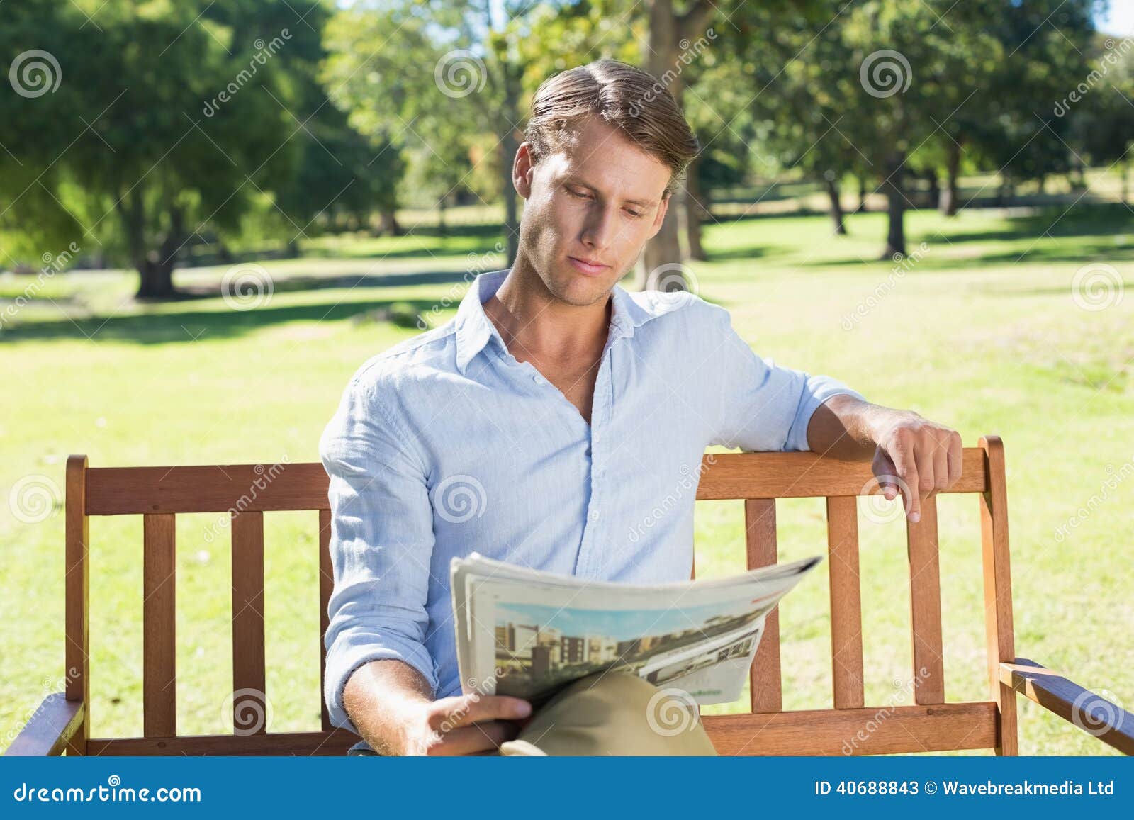 Handsome Man Sitting on Park Bench Reading Newspaper Stock Image ...