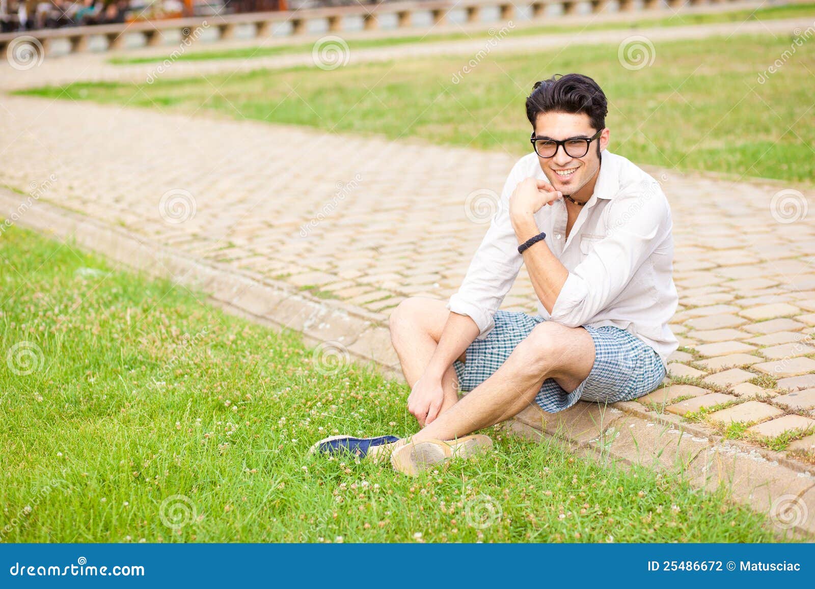 Handsome Man Sitting on the Sidewalk and Smiling Stock Photo - Image of ...