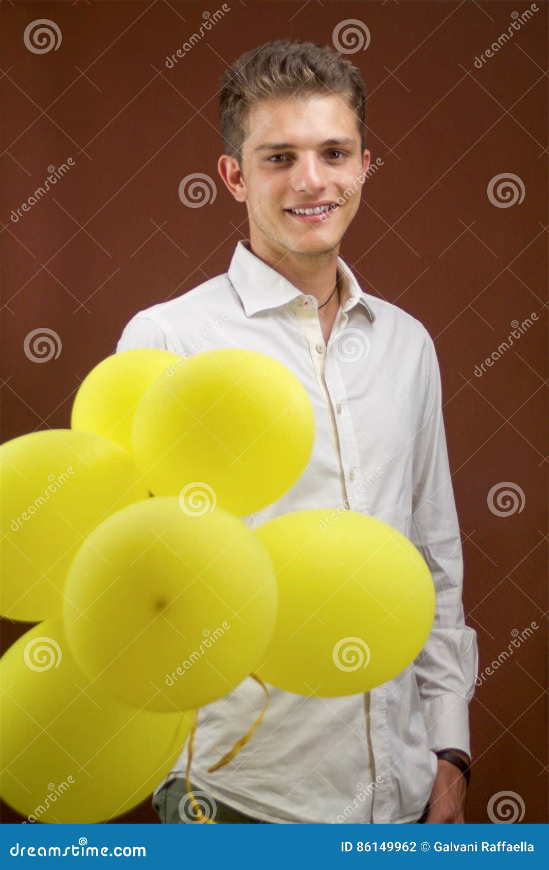 Handsome Man Smiling with a Group of Yellow Balloons Stock Photo ...