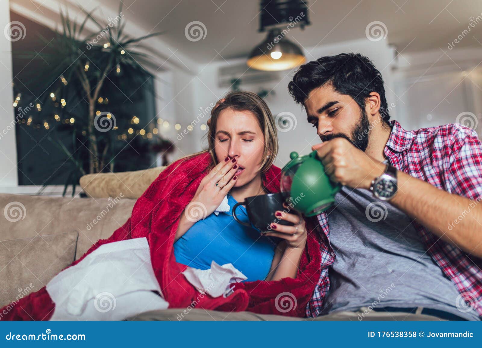 Man Taking Care of His Sick Girlfriend Lying on the Sofa Stock Photo ...