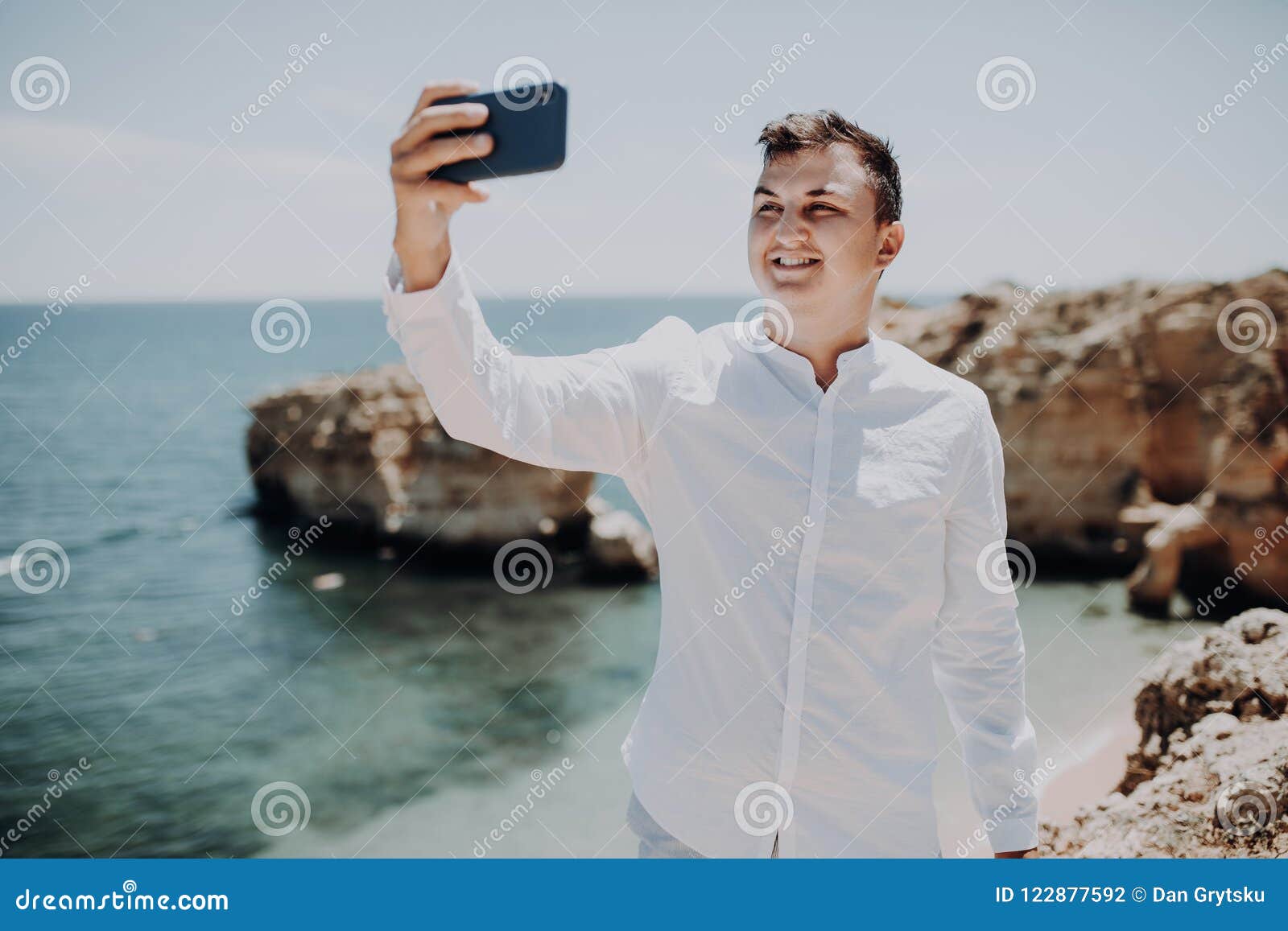 Handsome Man Taking A Selfie On Vacation On Ocean And Cliff Background