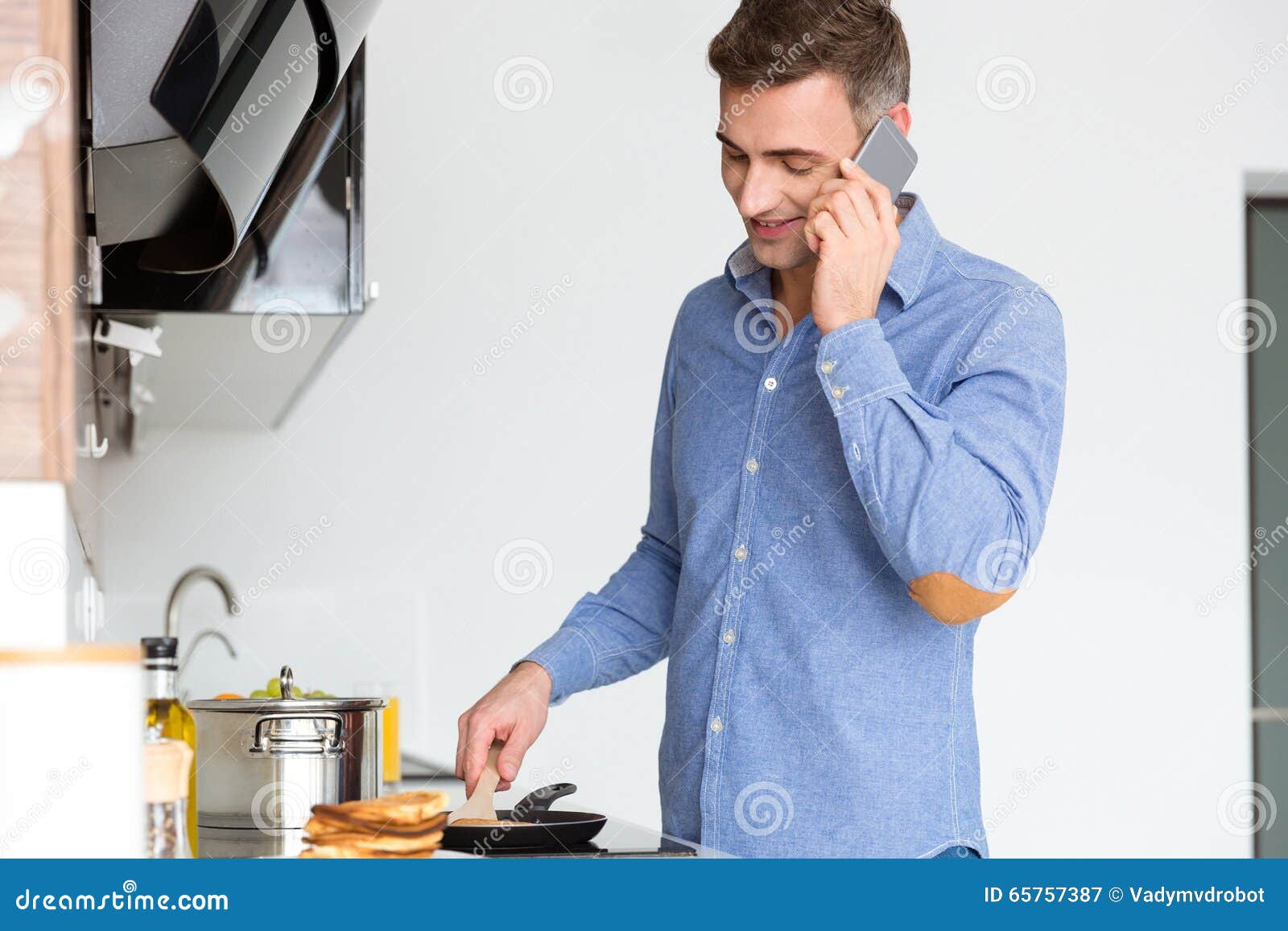 Handsome Man Talking on Cell Phone and Frying Pancakes Stock Image ...