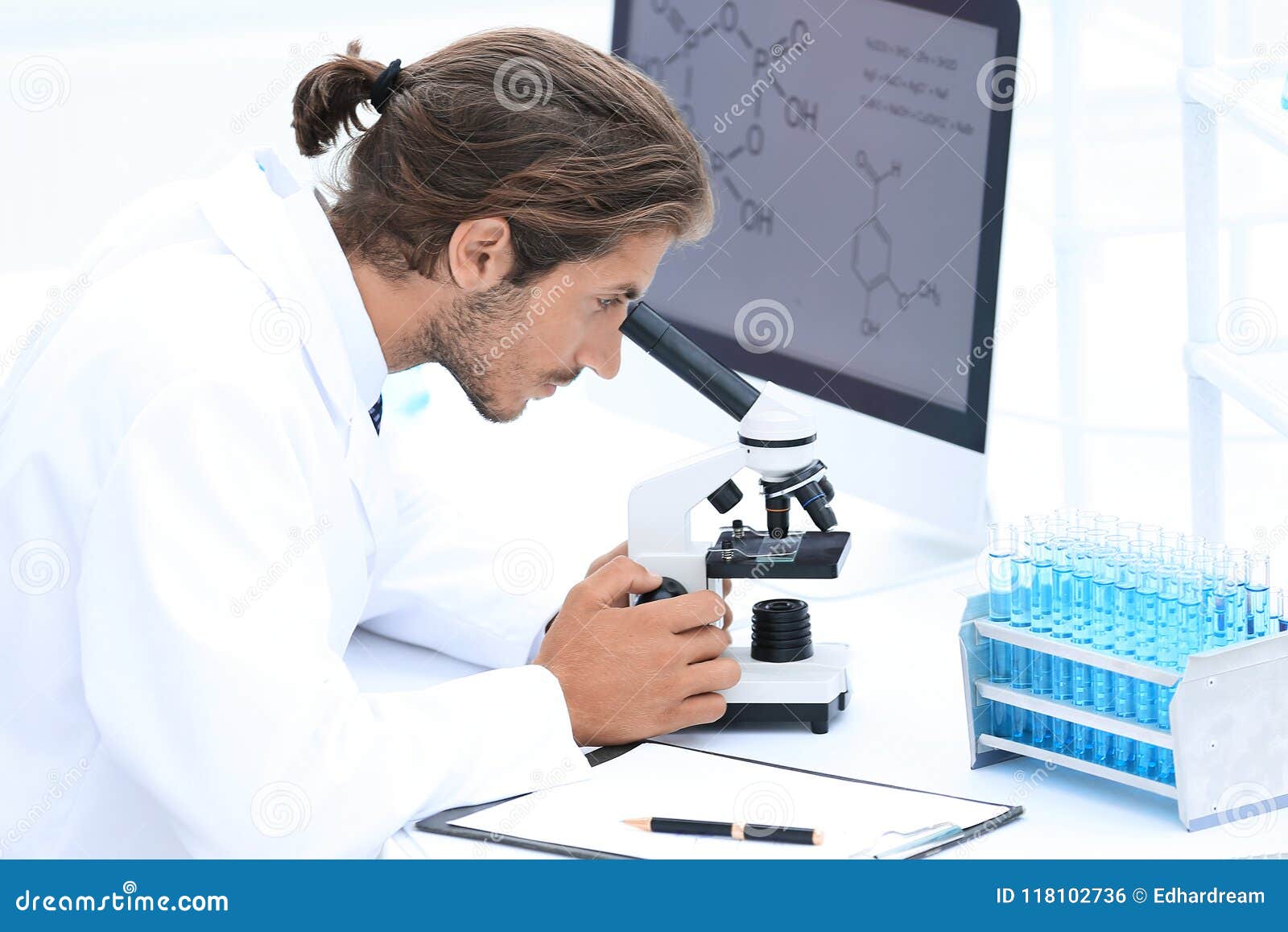 A Handsome Man Technician in the Lab Looking through Microscope Stock ...