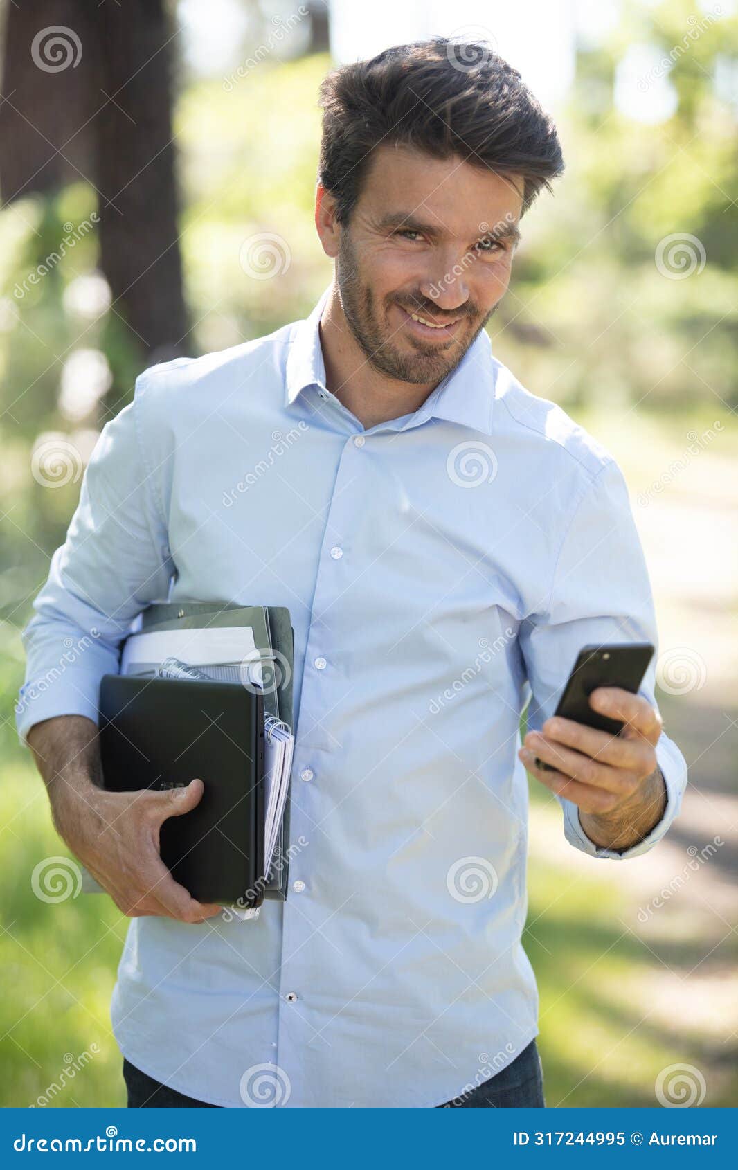 Handsome Man Texting on Cellphone while Holding Paper in Hand Stock ...