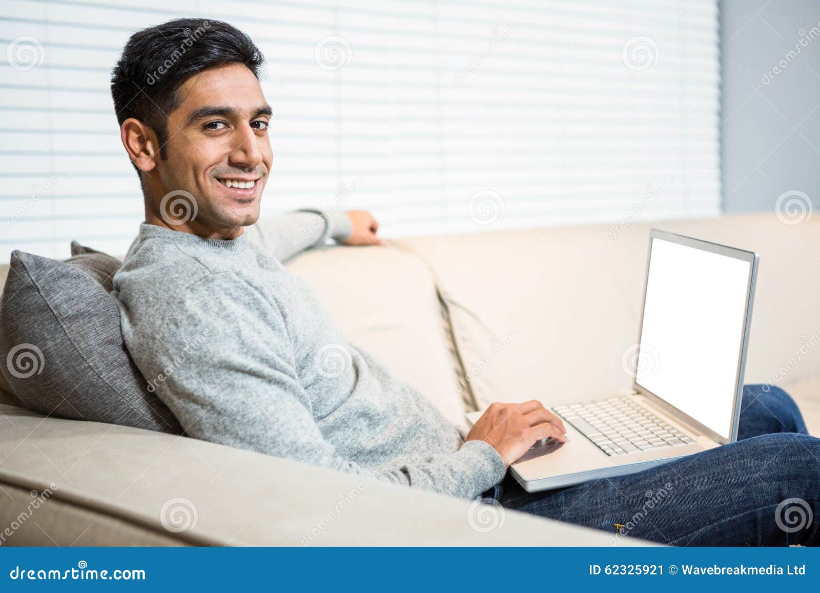 Handsome Man Using Laptop on Sofa Stock Image - Image of room, sitting ...
